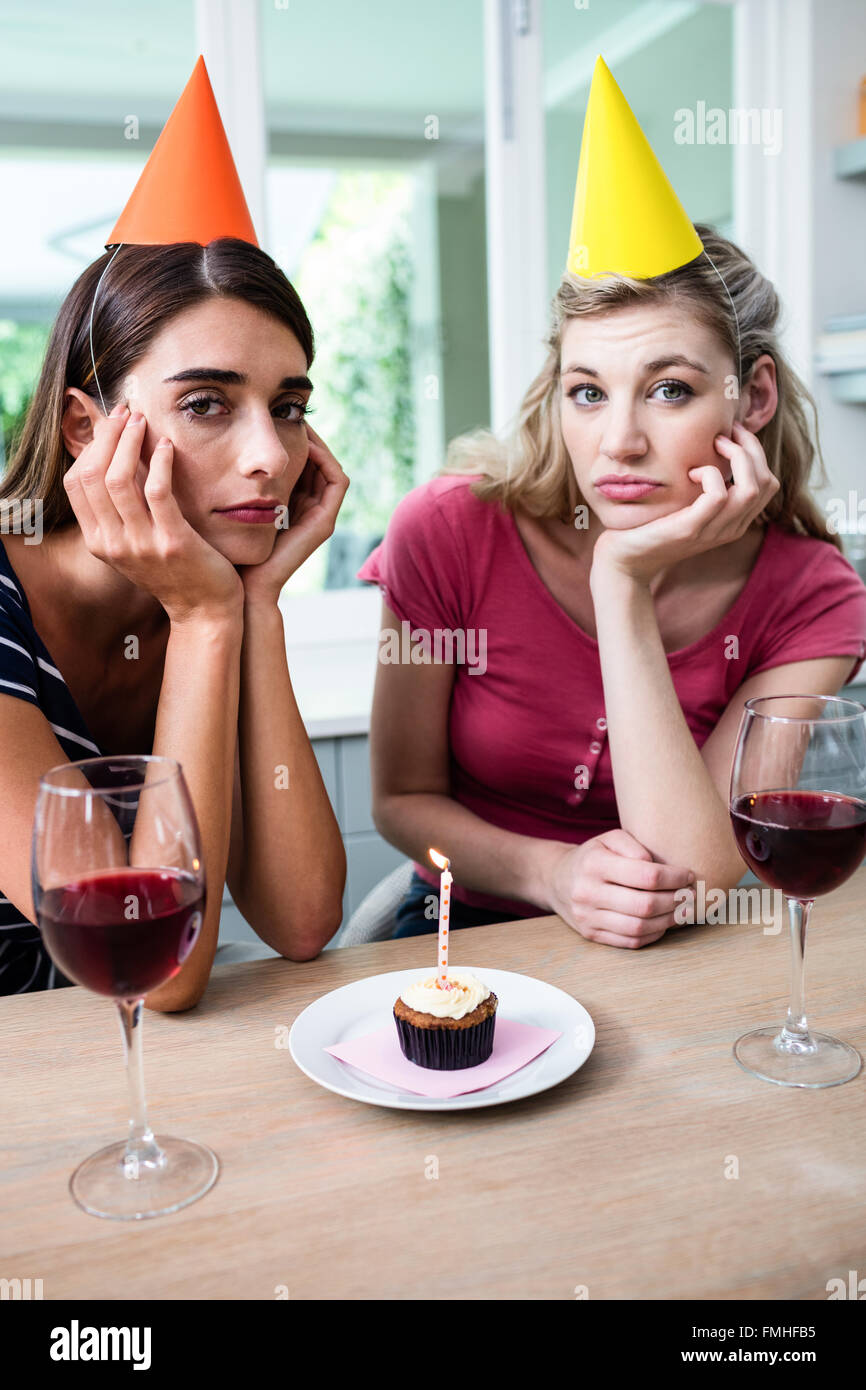 Portrait of sad friends sitting at table during birthday party Stock ...