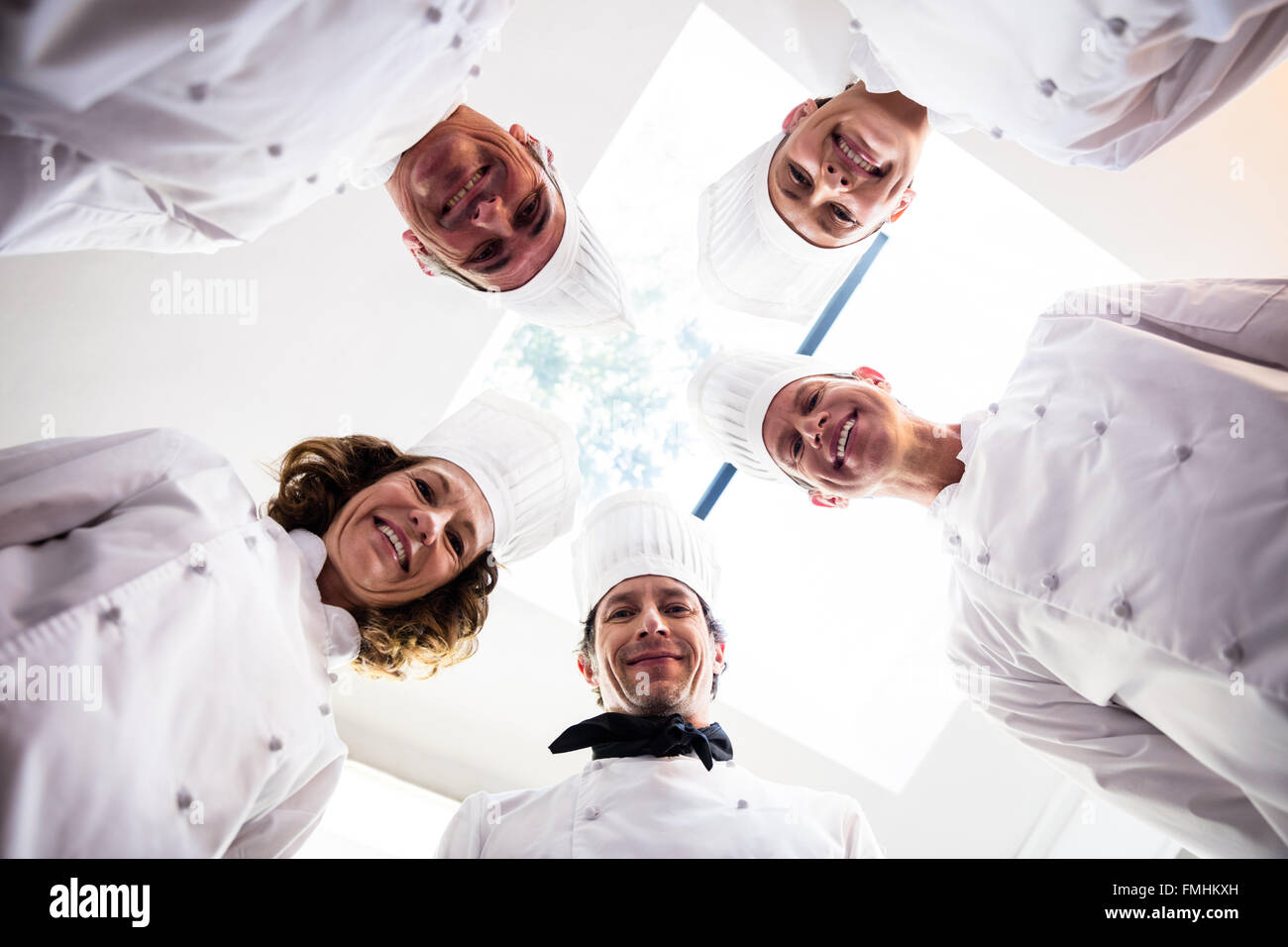 Portrait of chefs team standing in a circle wearing uniforms Stock ...