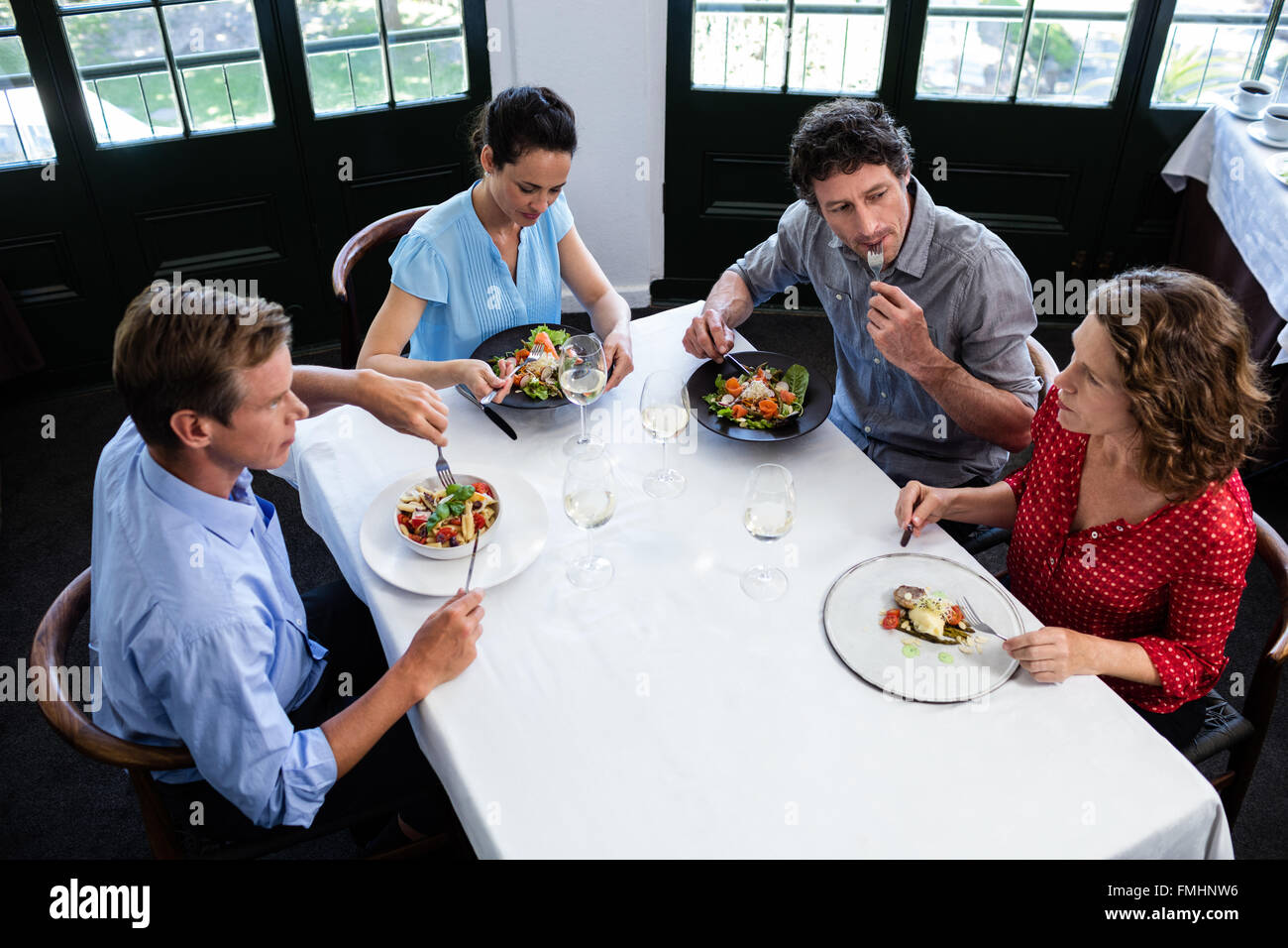 Group of friends talking while having lunch Stock Photo - Alamy
