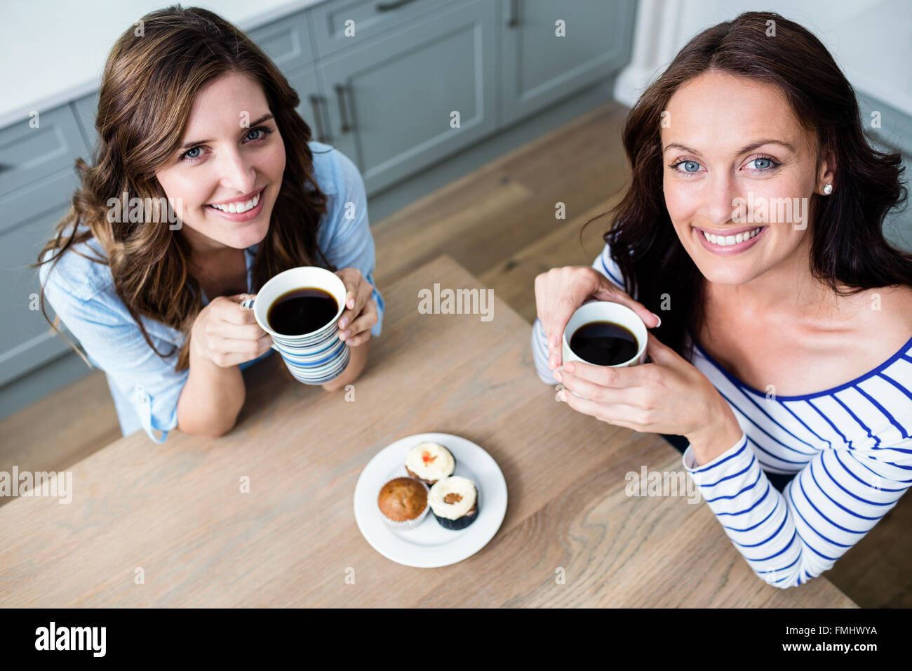 High angle portrait of female friends holding coffee mugs Stock Photo ...