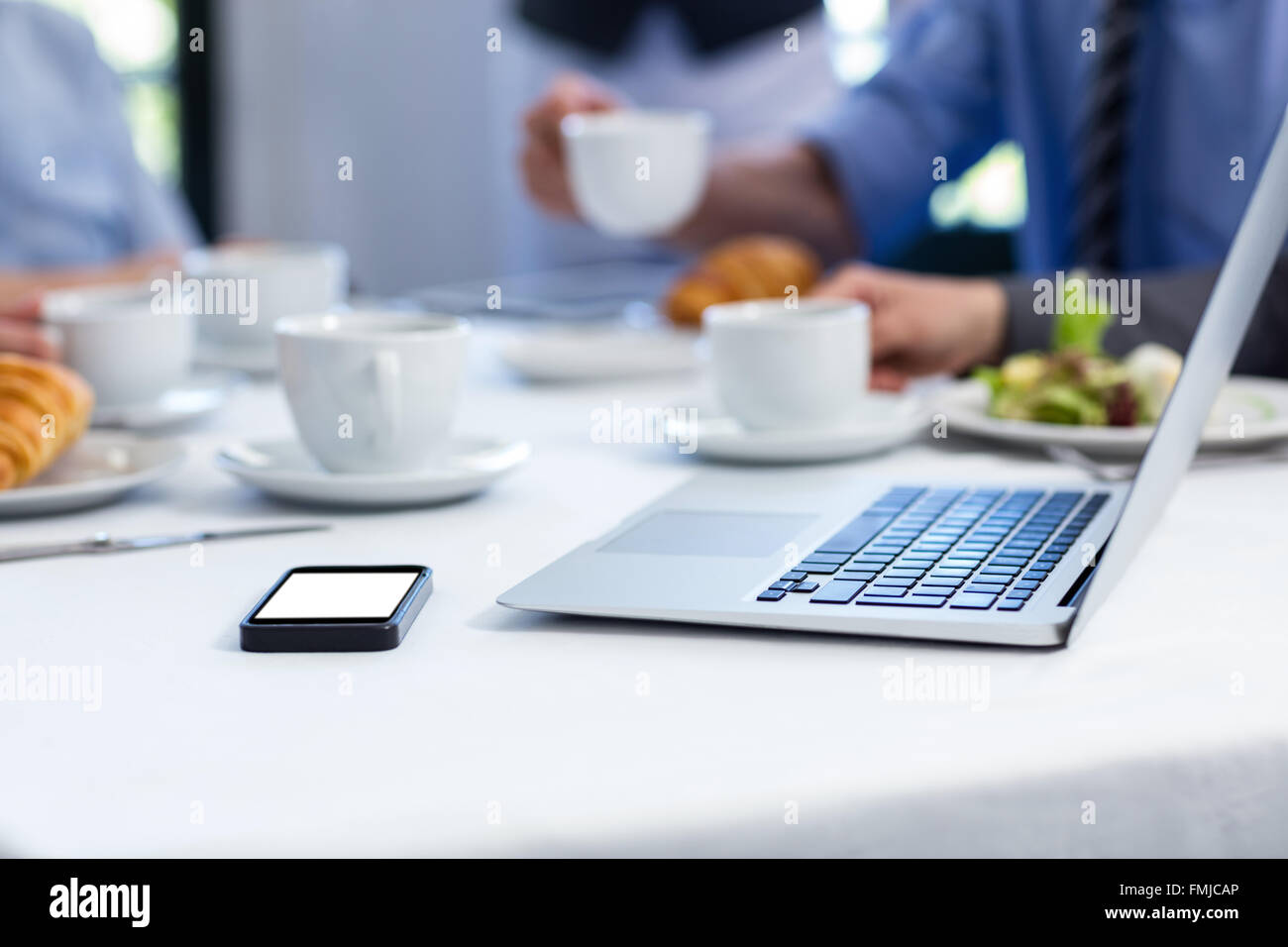 Laptop and mobile phone on the restaurant table Stock Photo - Alamy