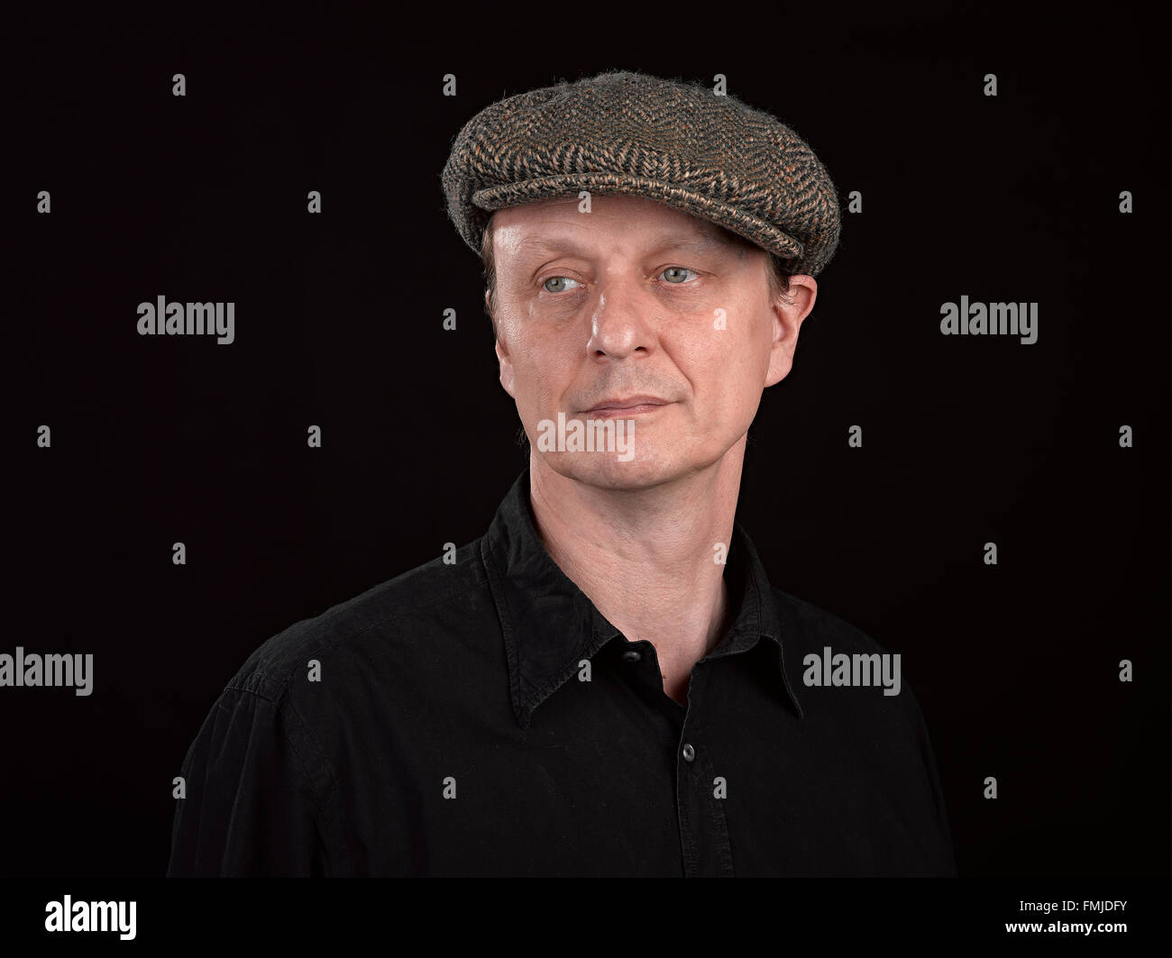 A male model wearing a patterned side hat on black background Stock ...