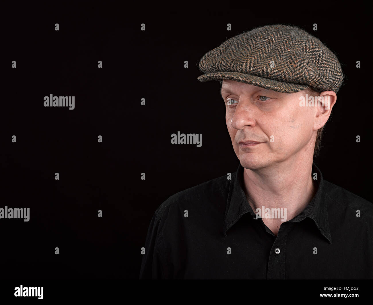 A male model wearing a patterned side hat on black background Stock ...