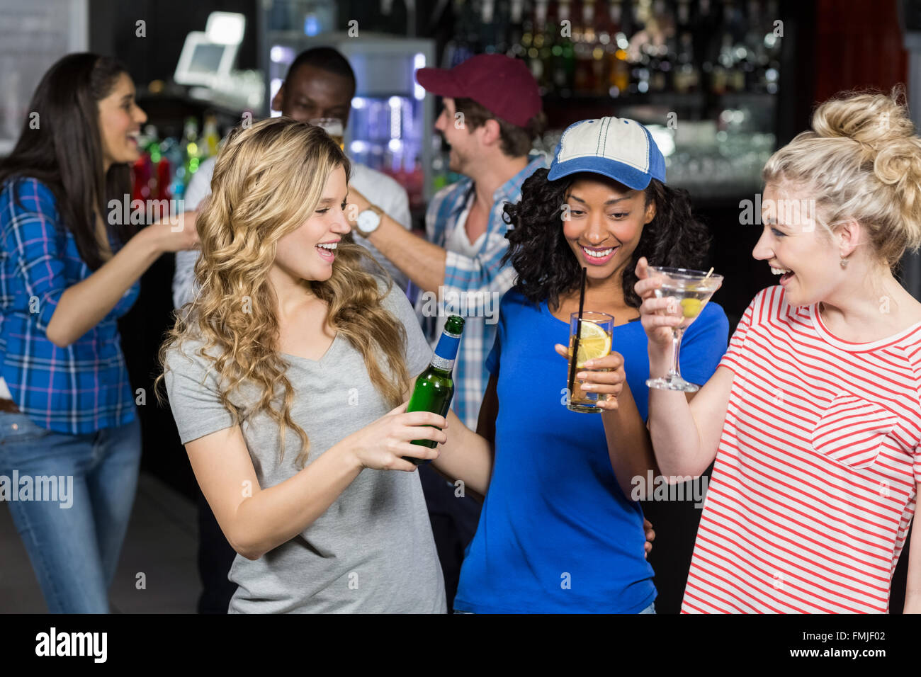 Happy friends drinking cocktails Stock Photo - Alamy