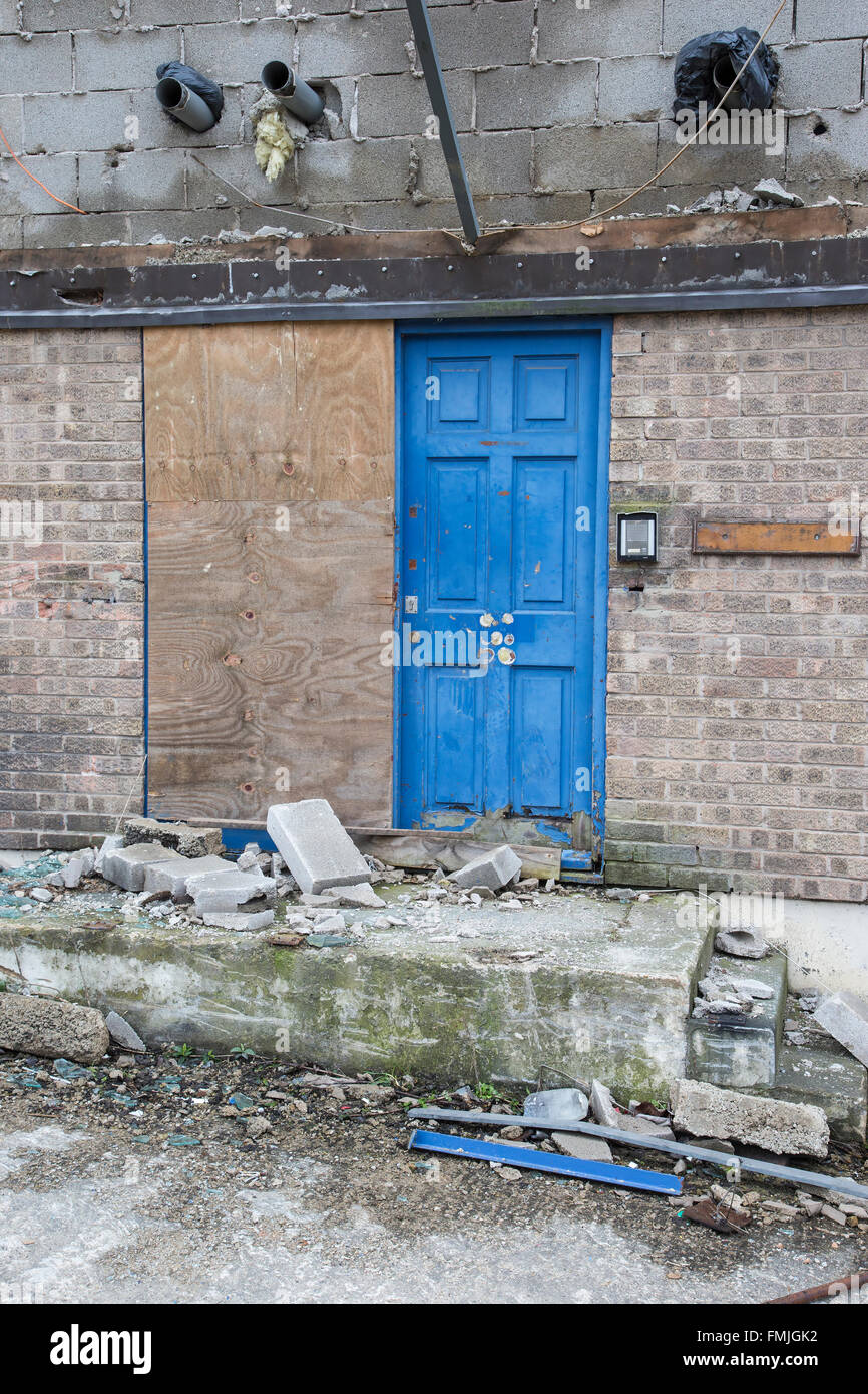 Damaged wooden door and access steps of a factory building undergoing ...