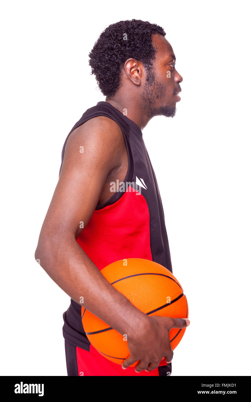 Side view of a basketball player holding a basketball, isolated on ...