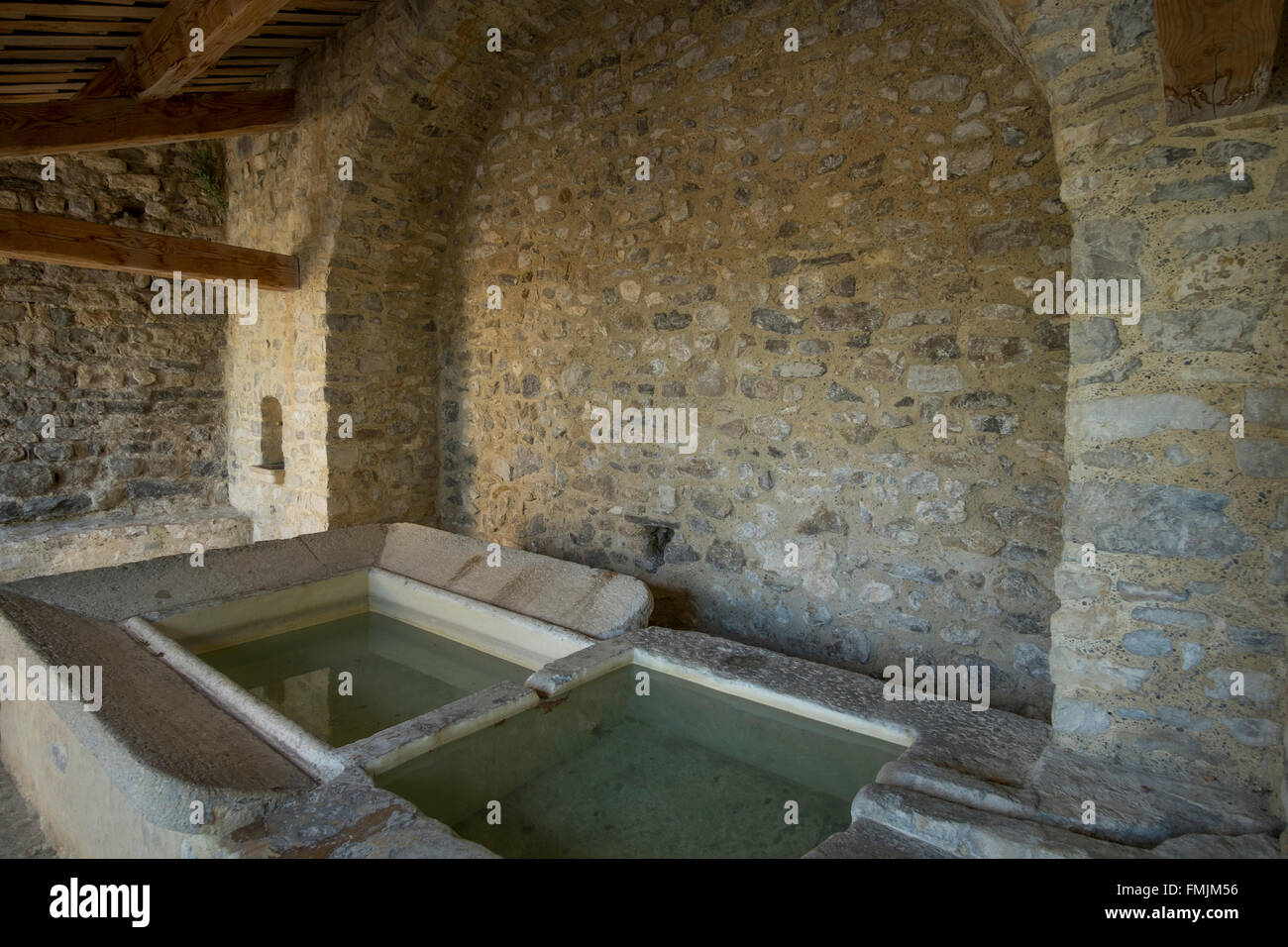 Traditional open air laundry room with running water in stone troughs ...