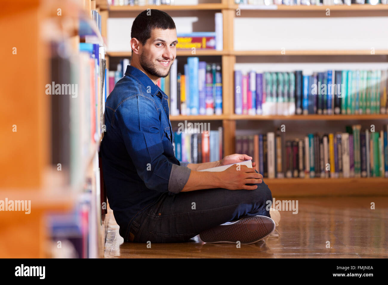 Male student reading a book at the library Stock Photo - Alamy