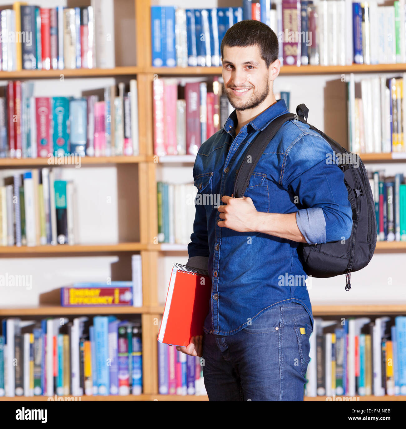 Male student stand smiling at the library Stock Photo - Alamy