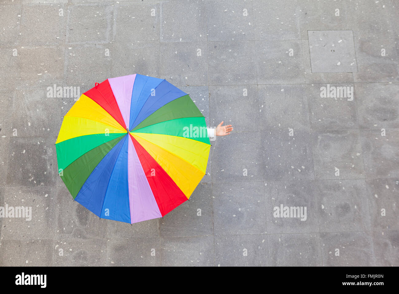 Woman hidden under multicolor umbrella Stock Photo - Alamy