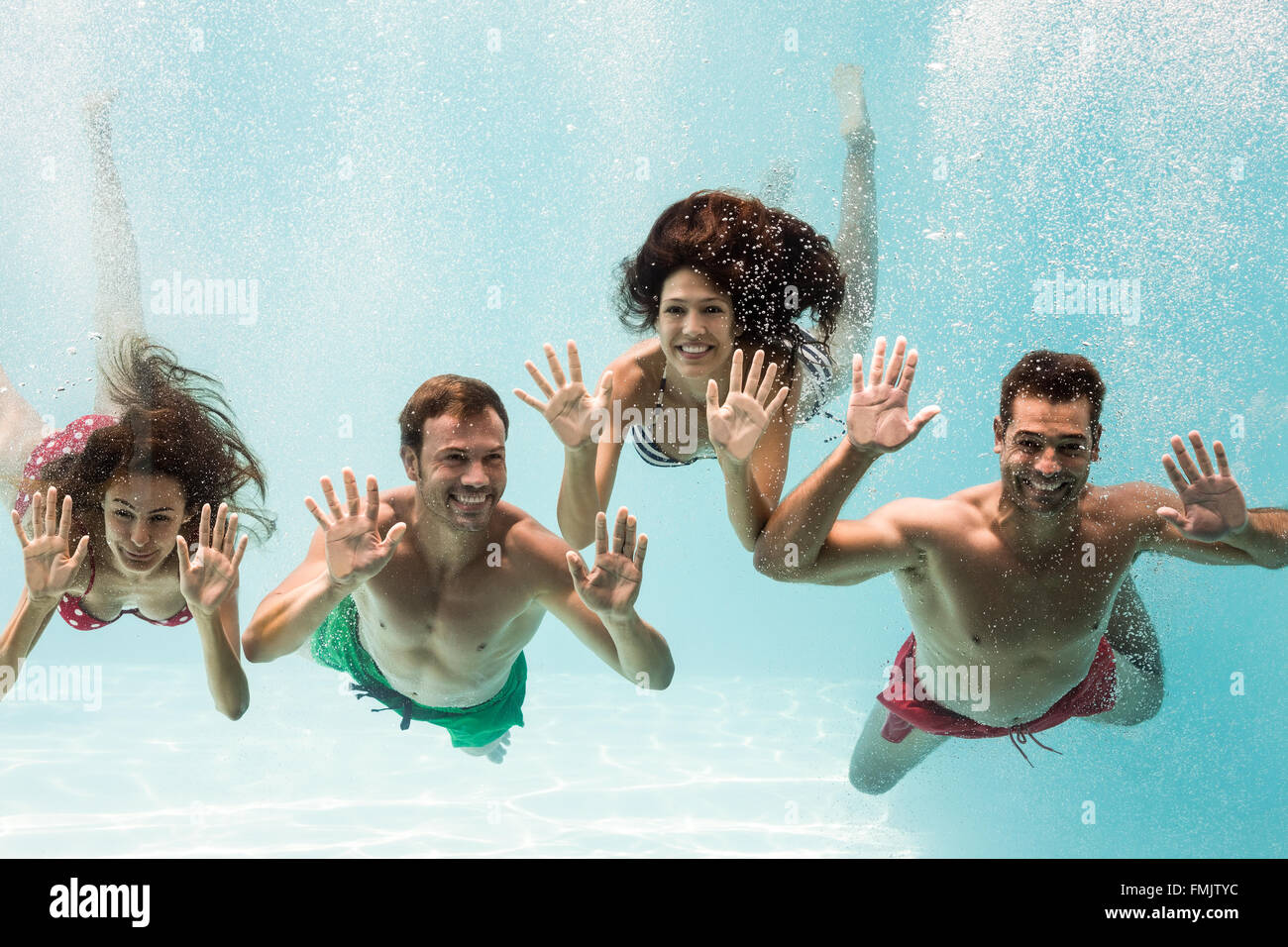 Portrait of cheerful friends swimming Stock Photo - Alamy