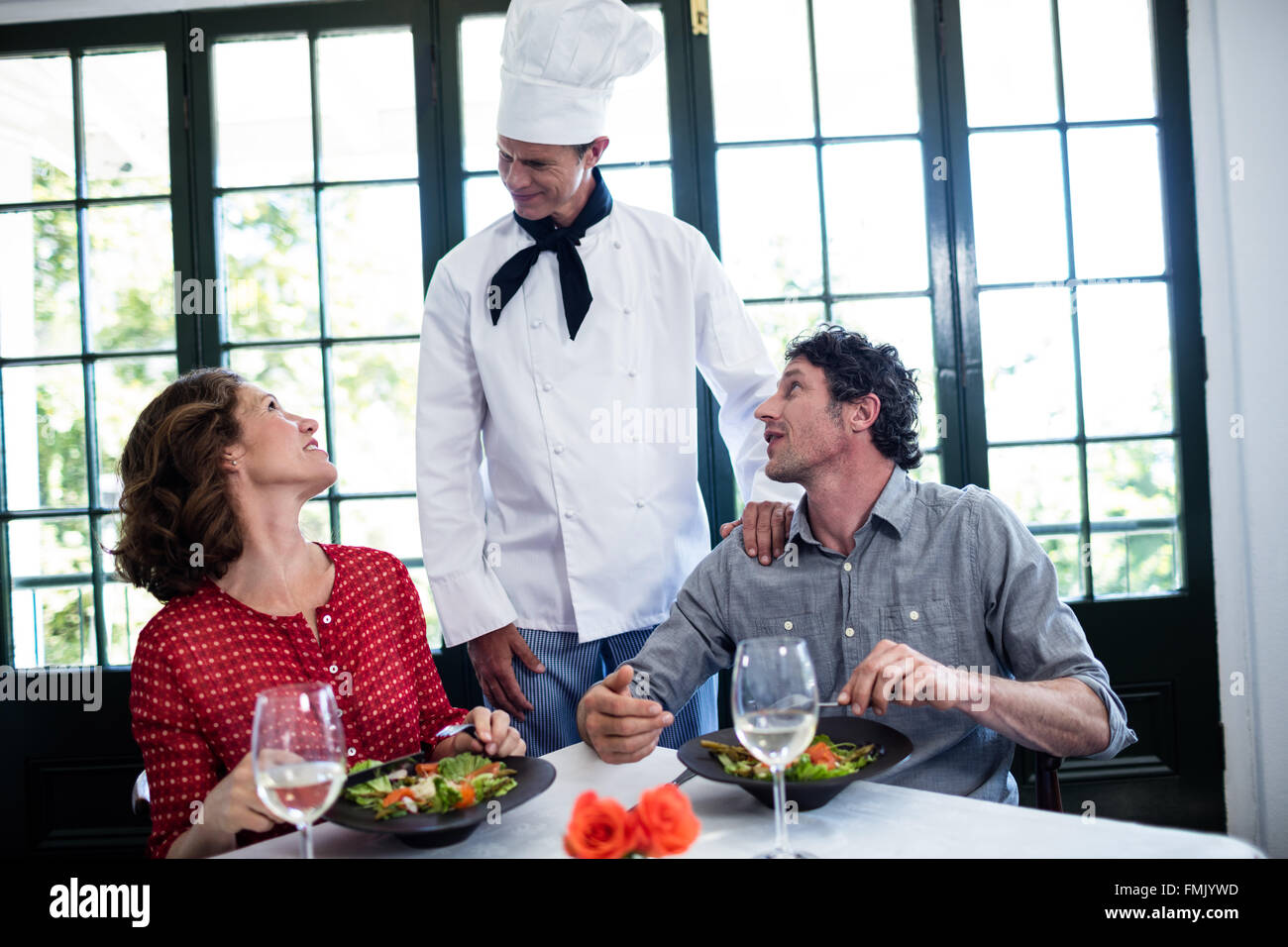 Chef talking to couple Stock Photo - Alamy