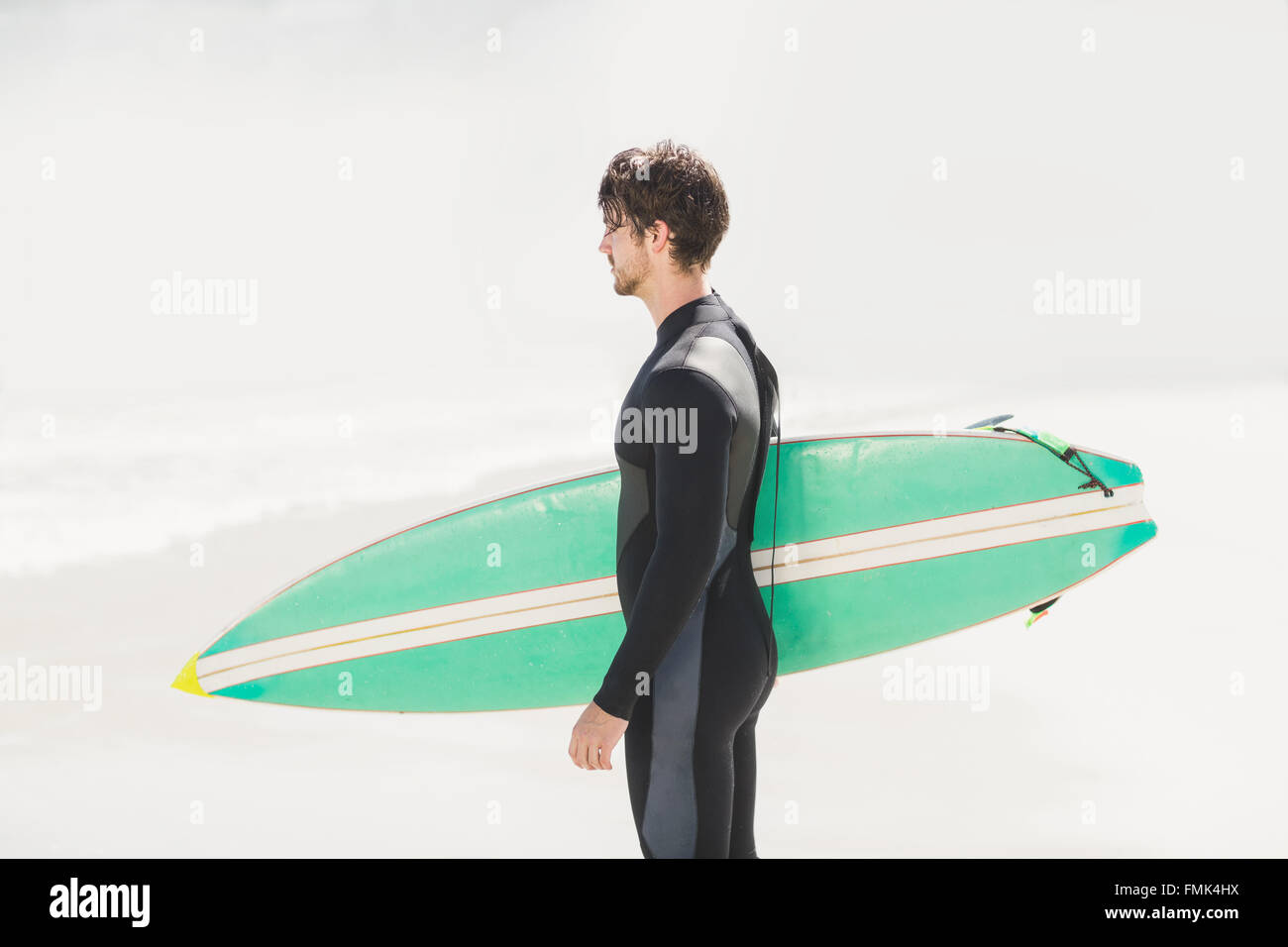 Man holding surfboard on the beach Stock Photo - Alamy