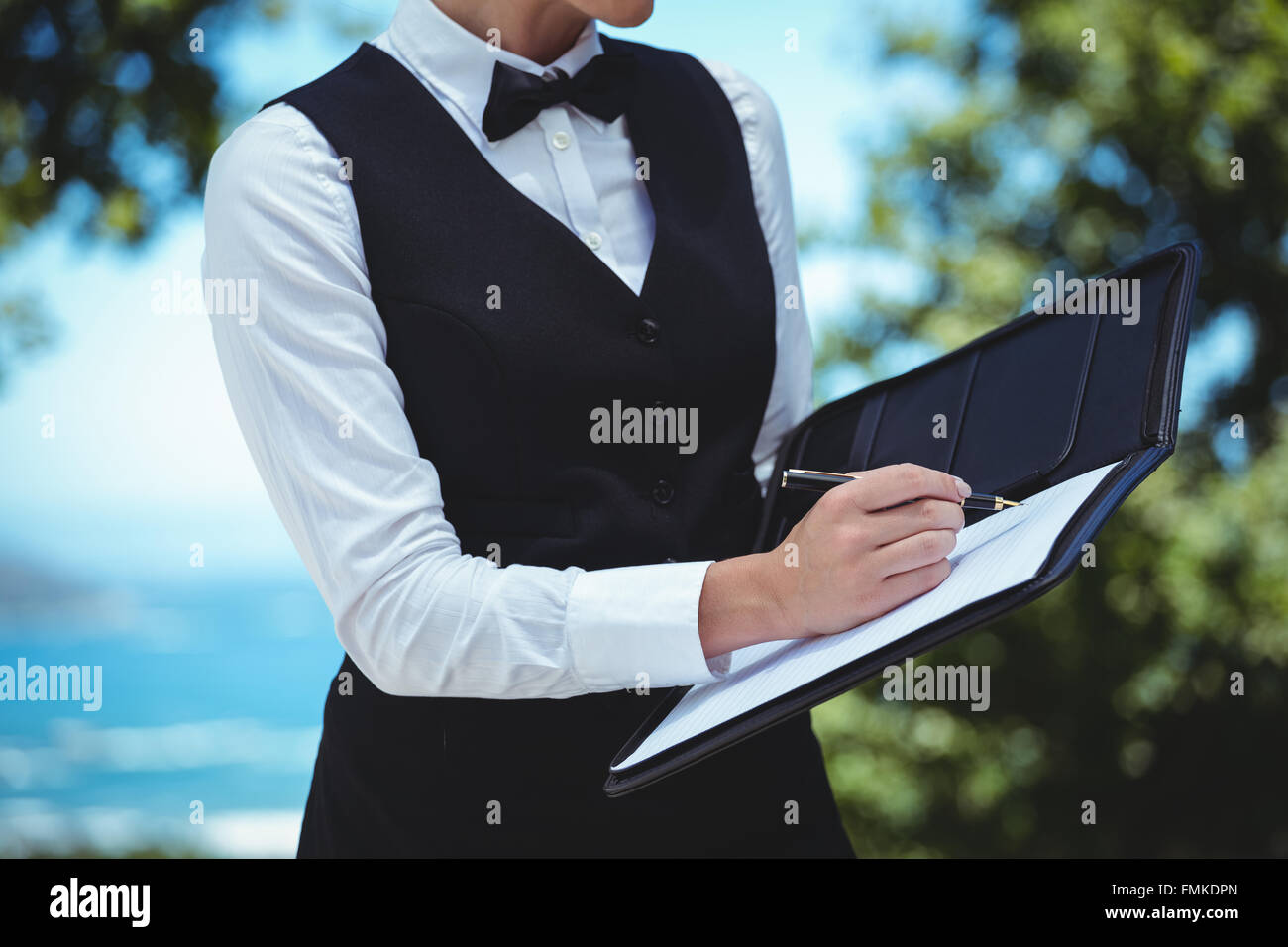 Smiling waitress taking an order Stock Photo - Alamy