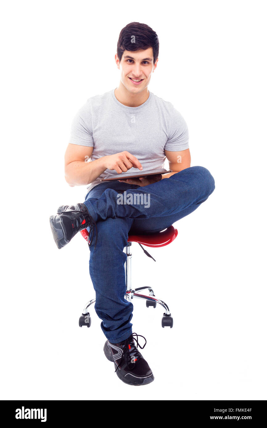 Smiling handsome latin man using a tablet computer, isolated over a ...