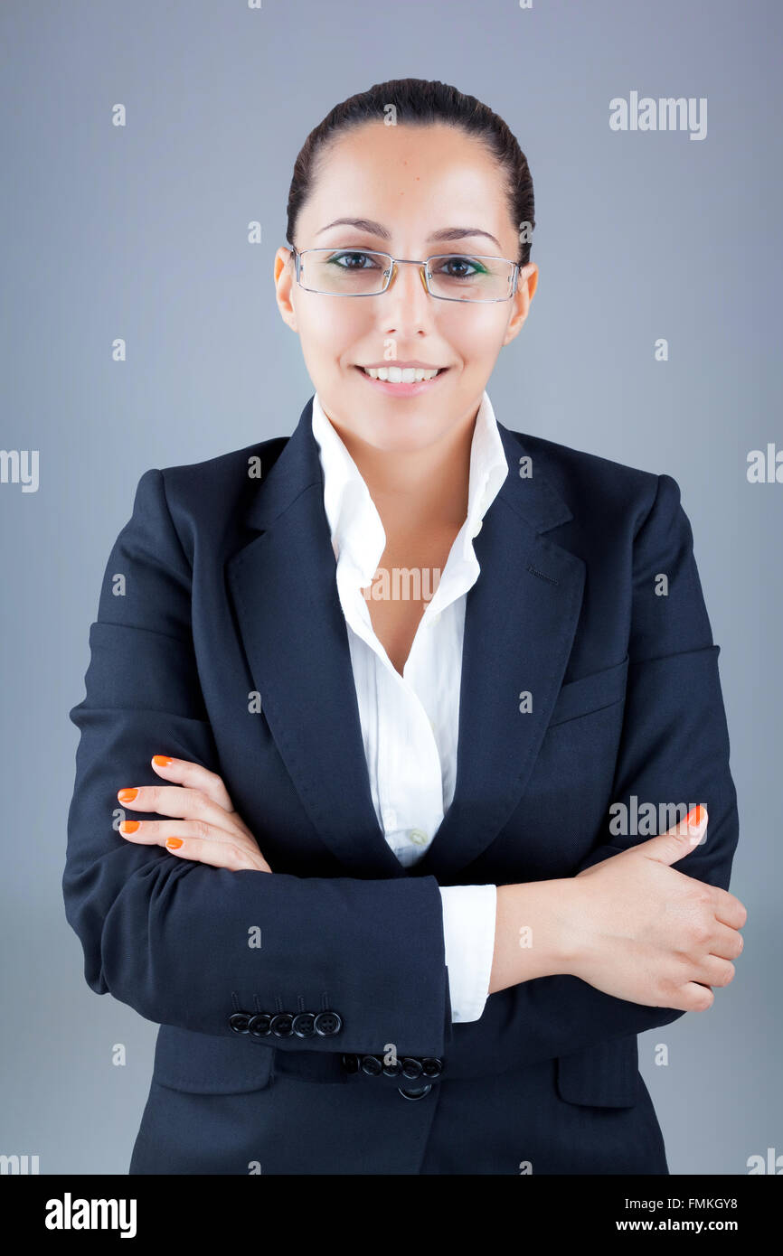 Portrait of beautiful business woman wearing glasses against grey ...