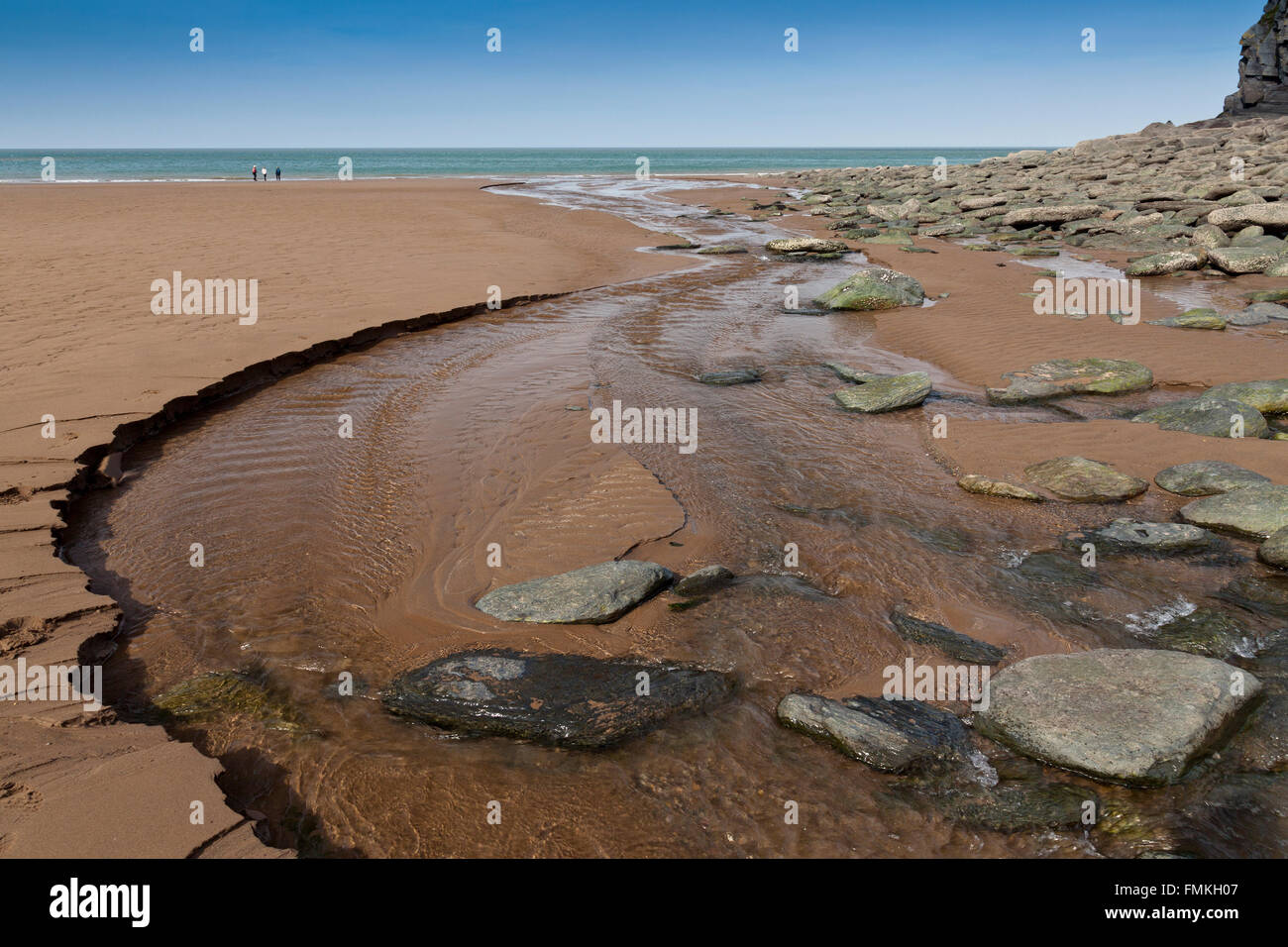 A stream from Exmoor crosses the beach at Lee Bay and empties into the ...