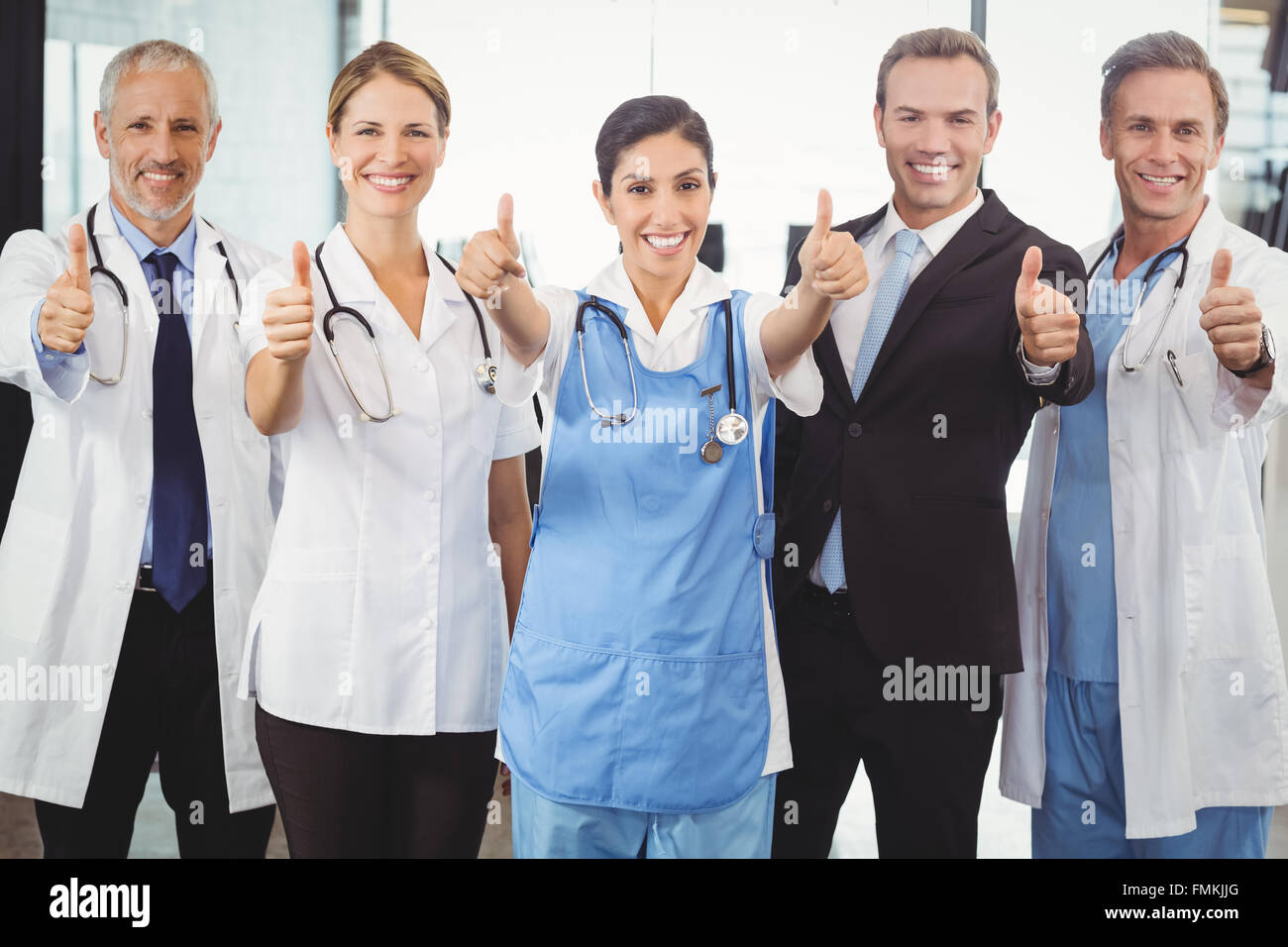 Medical team putting their thumbs up and smiling Stock Photo - Alamy