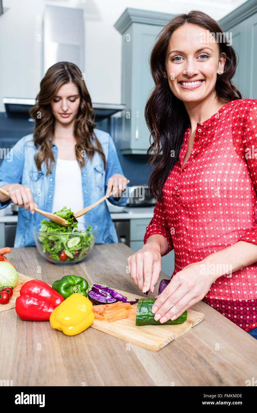 Happy female friends preparing salad Stock Photo - Alamy
