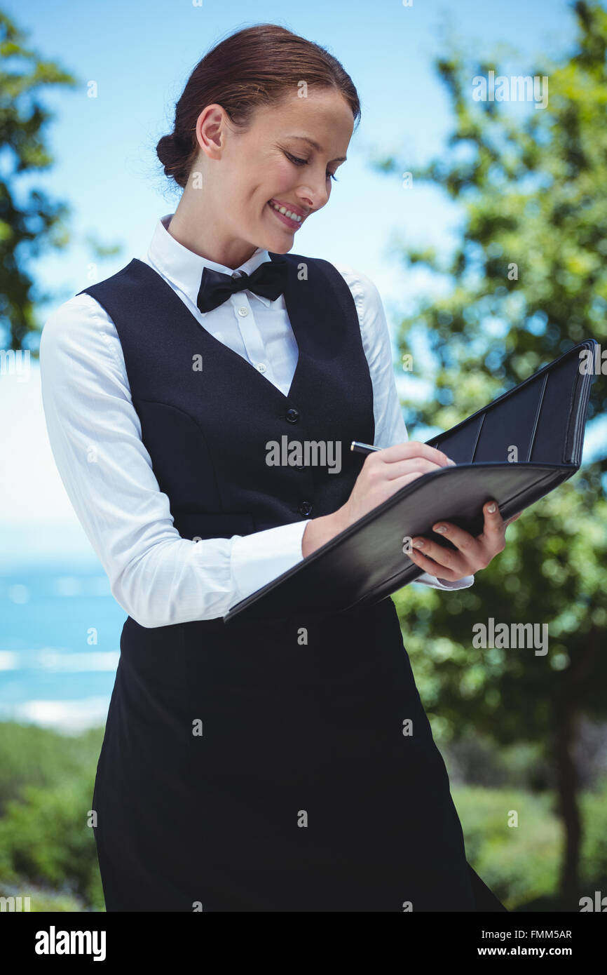 Smiling waitress taking an order Stock Photo - Alamy