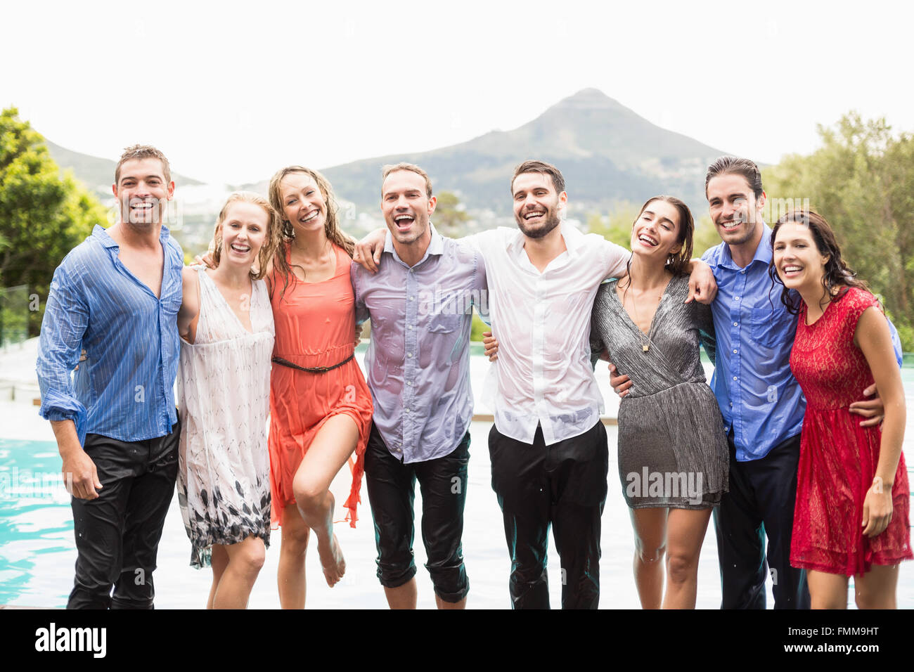 Cheerful friends standing by swimming pool Stock Photo - Alamy
