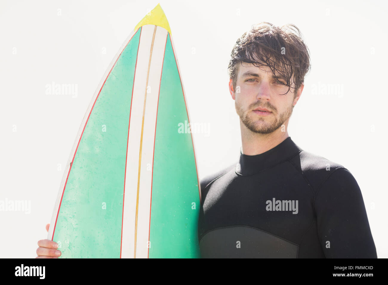 Man holding surfboard on the beach Stock Photo - Alamy