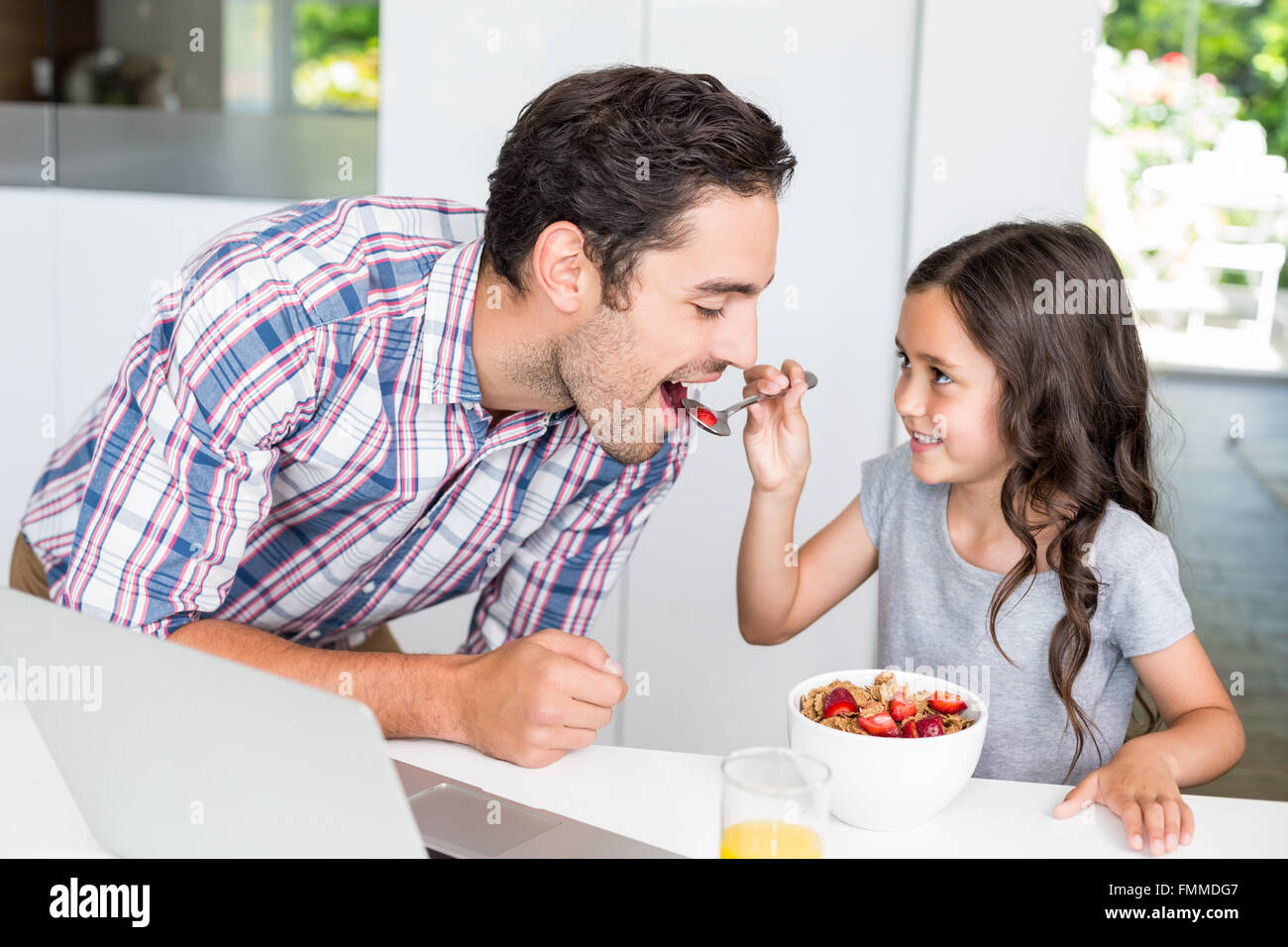 Smiling daughter feeding food to father Stock Photo - Alamy