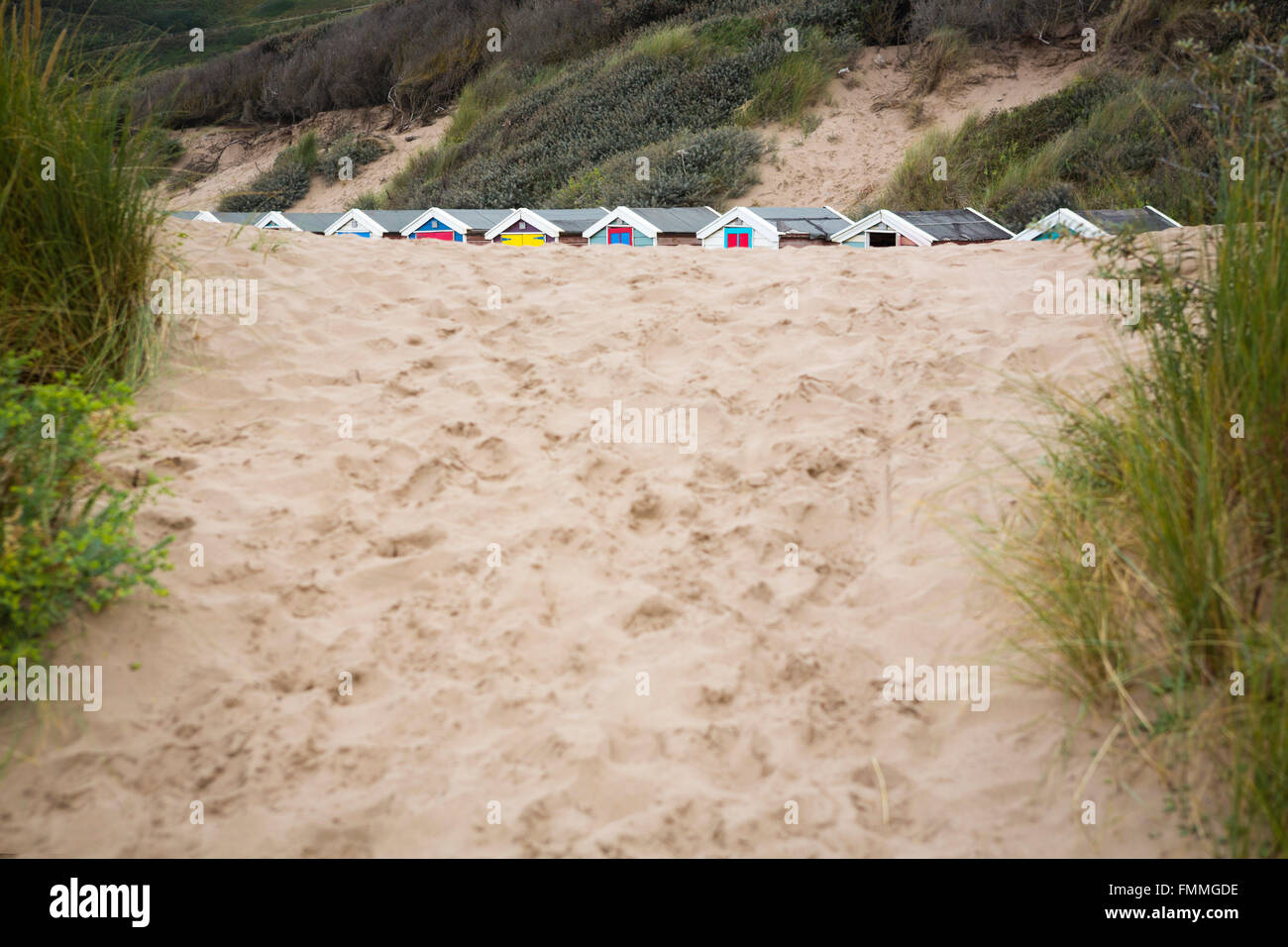 A line of beach huts hidden by the sand dunes Stock Photo - Alamy