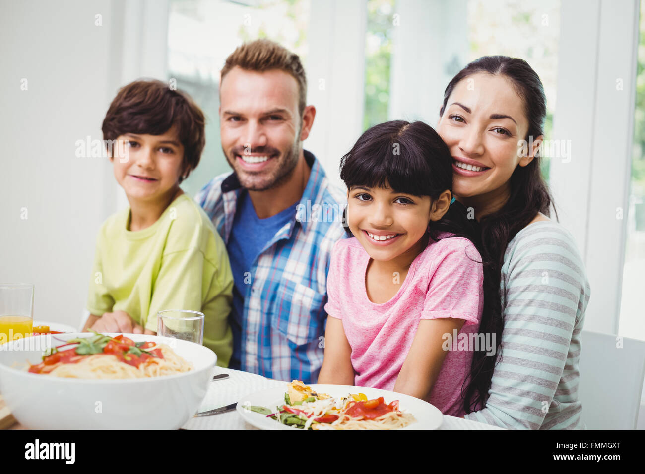 Portrait of smiling parents and siblings at dining table Stock Photo ...