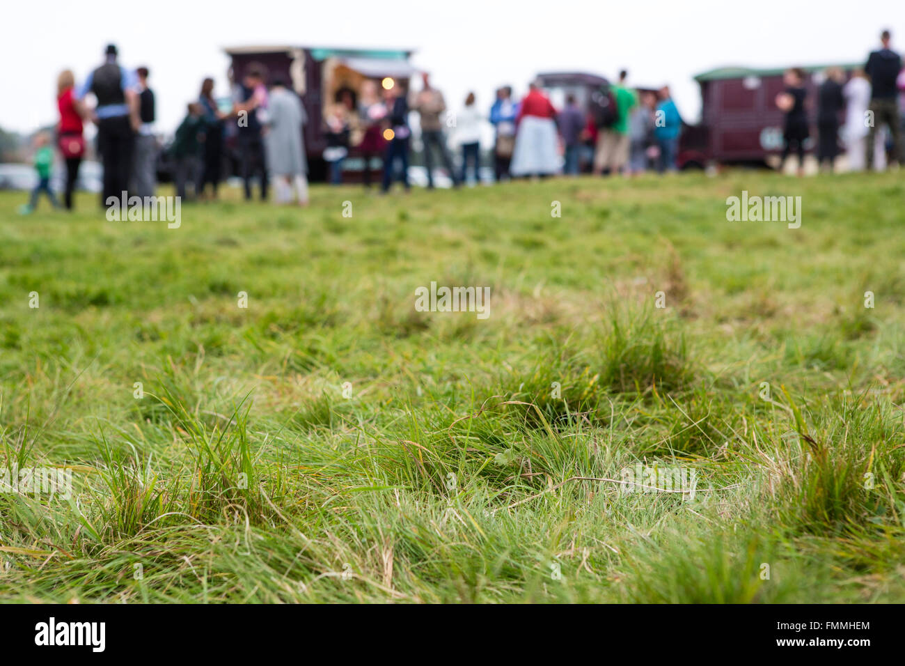 An event with crowds of people walking aorund a small field Stock Photo ...