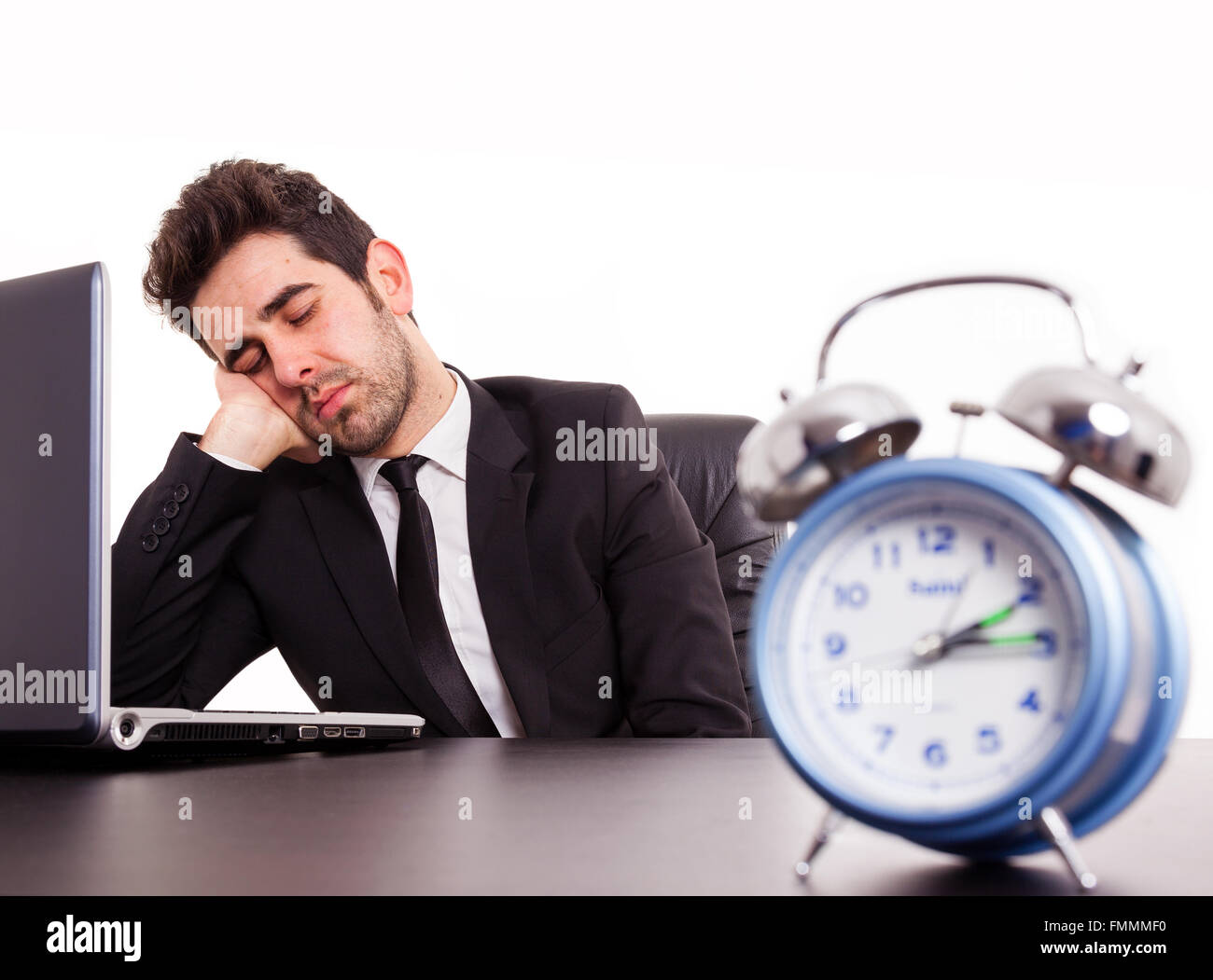 Tired young businessman sleeping next laptop on white background Stock ...