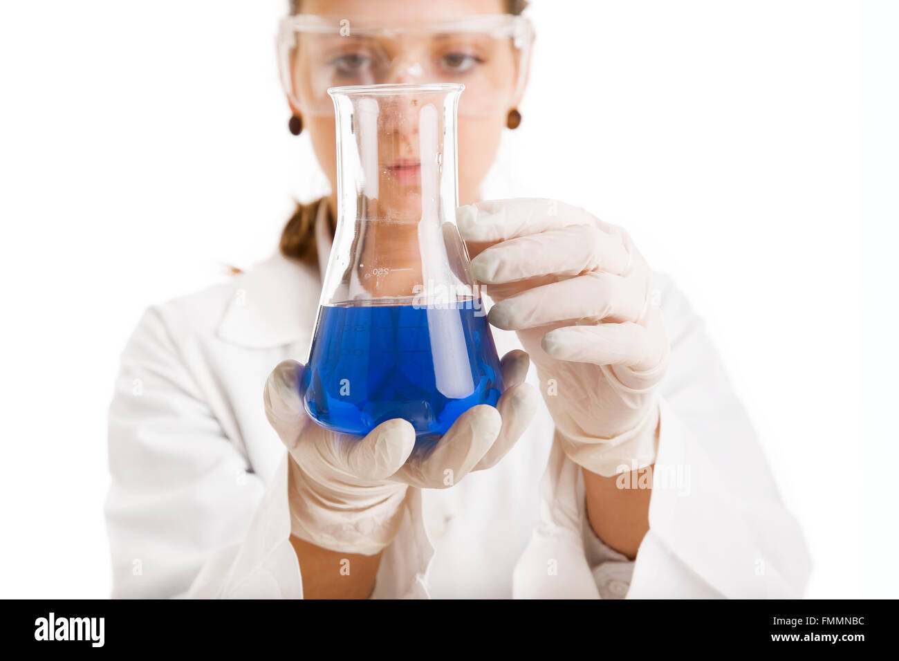 Female scientist looking at beaker of liquid Stock Photo - Alamy