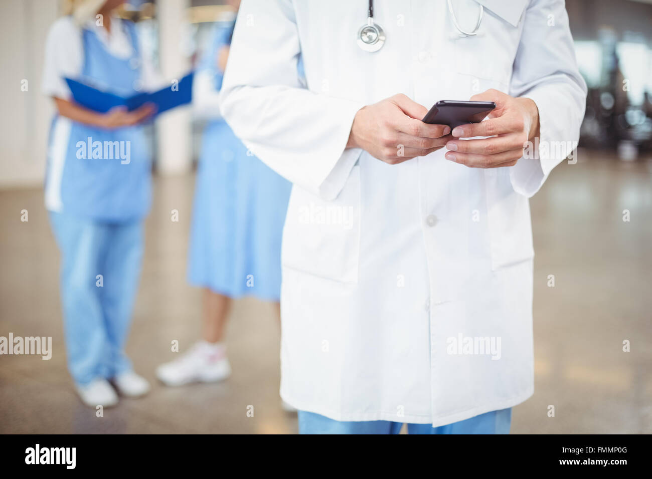 Midsection of doctor using mobile phone Stock Photo - Alamy