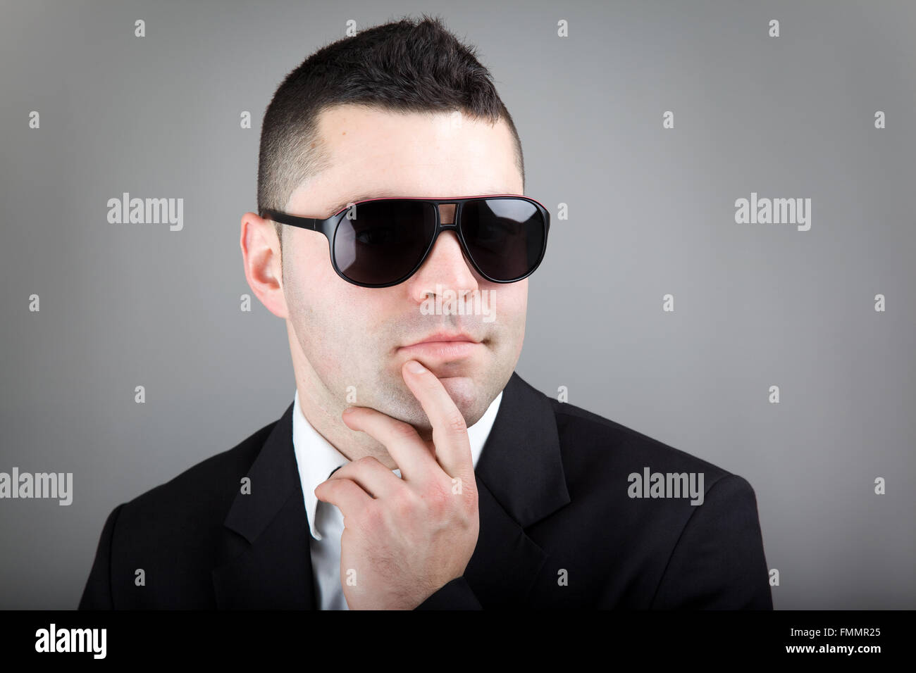 Portrait of secret agent standing in black suit Stock Photo - Alamy