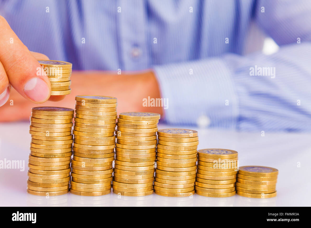 A Businessman rising coins Stock Photo - Alamy