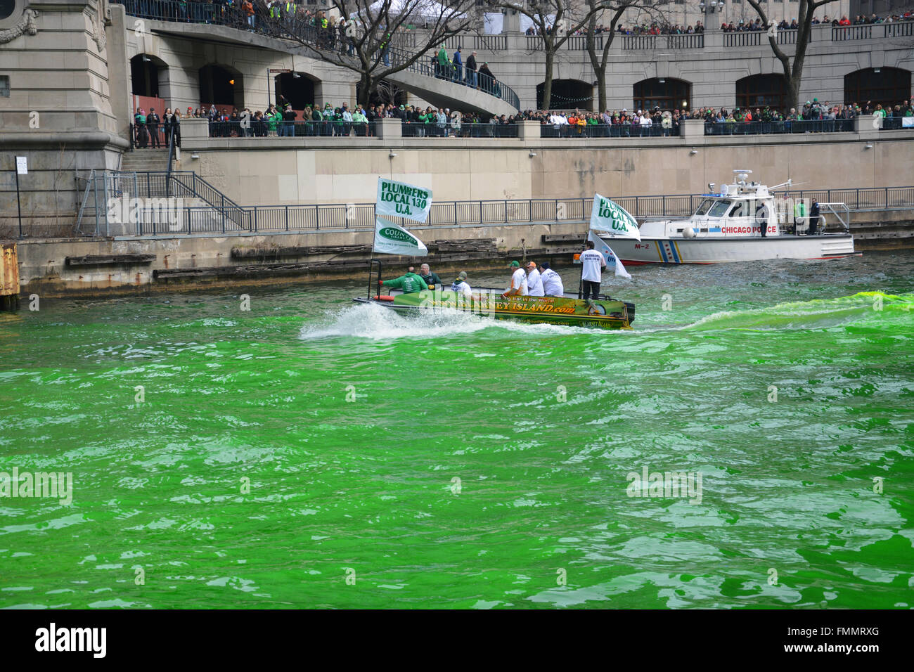 Tourists on the shore watch the Plumbers Union dye the Chicago River ...