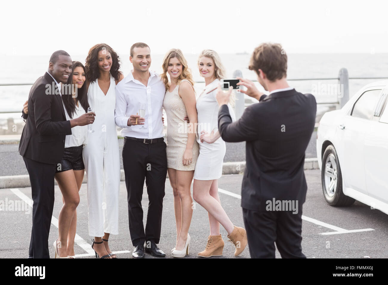 Well dressed people taking pictures next to a limousine Stock Photo - Alamy