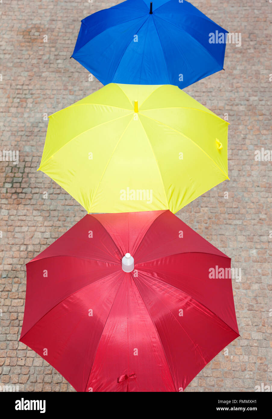 Three colorful umbrellas lined up Stock Photo - Alamy