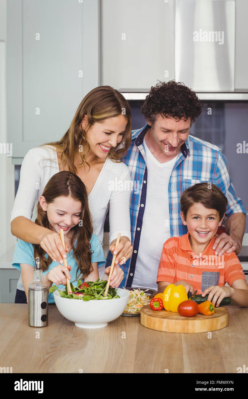 Happy family standing by table in kitchen Stock Photo - Alamy