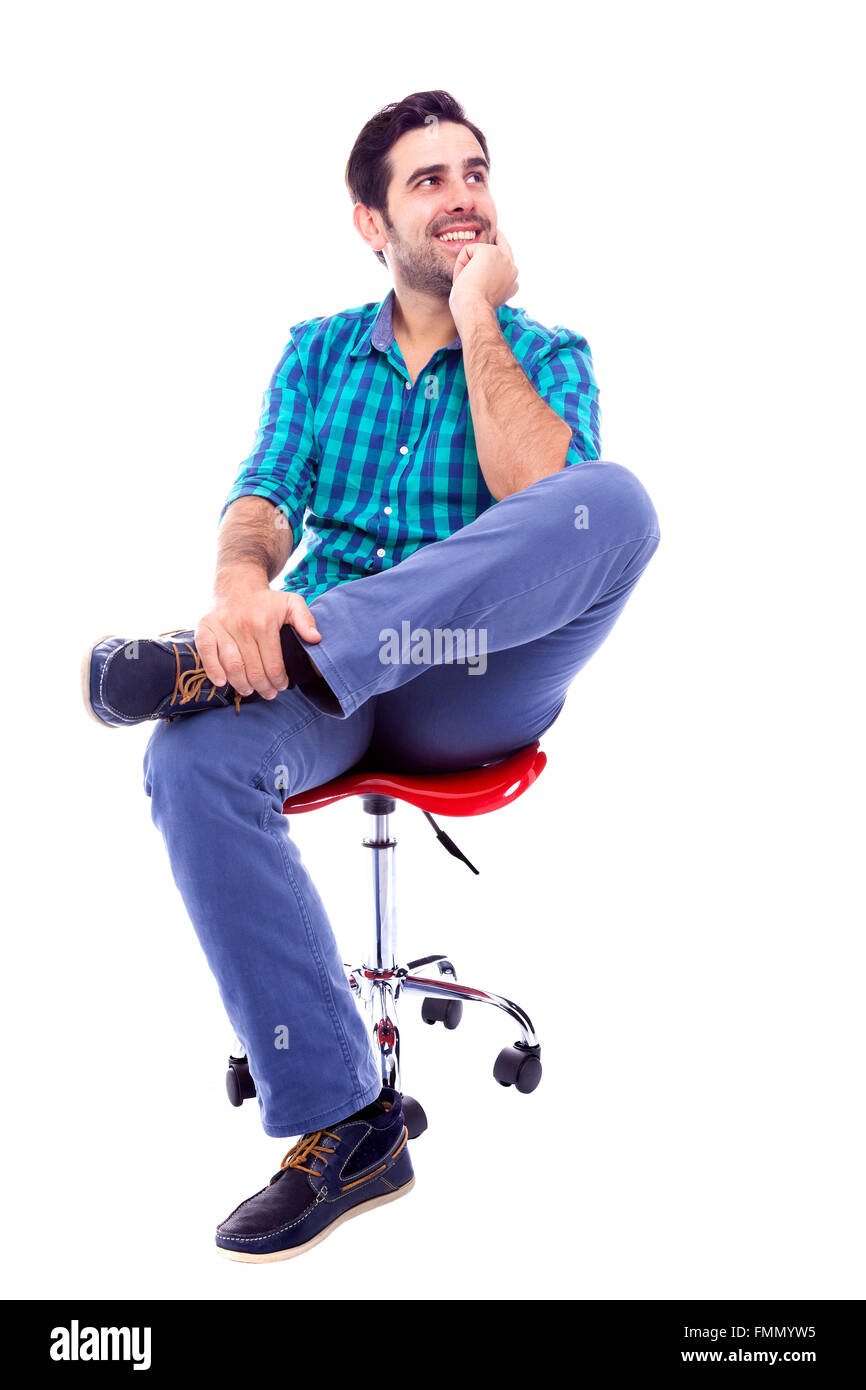 Portrait of a thoughtful smiling man sitting on the chair, isolated on ...