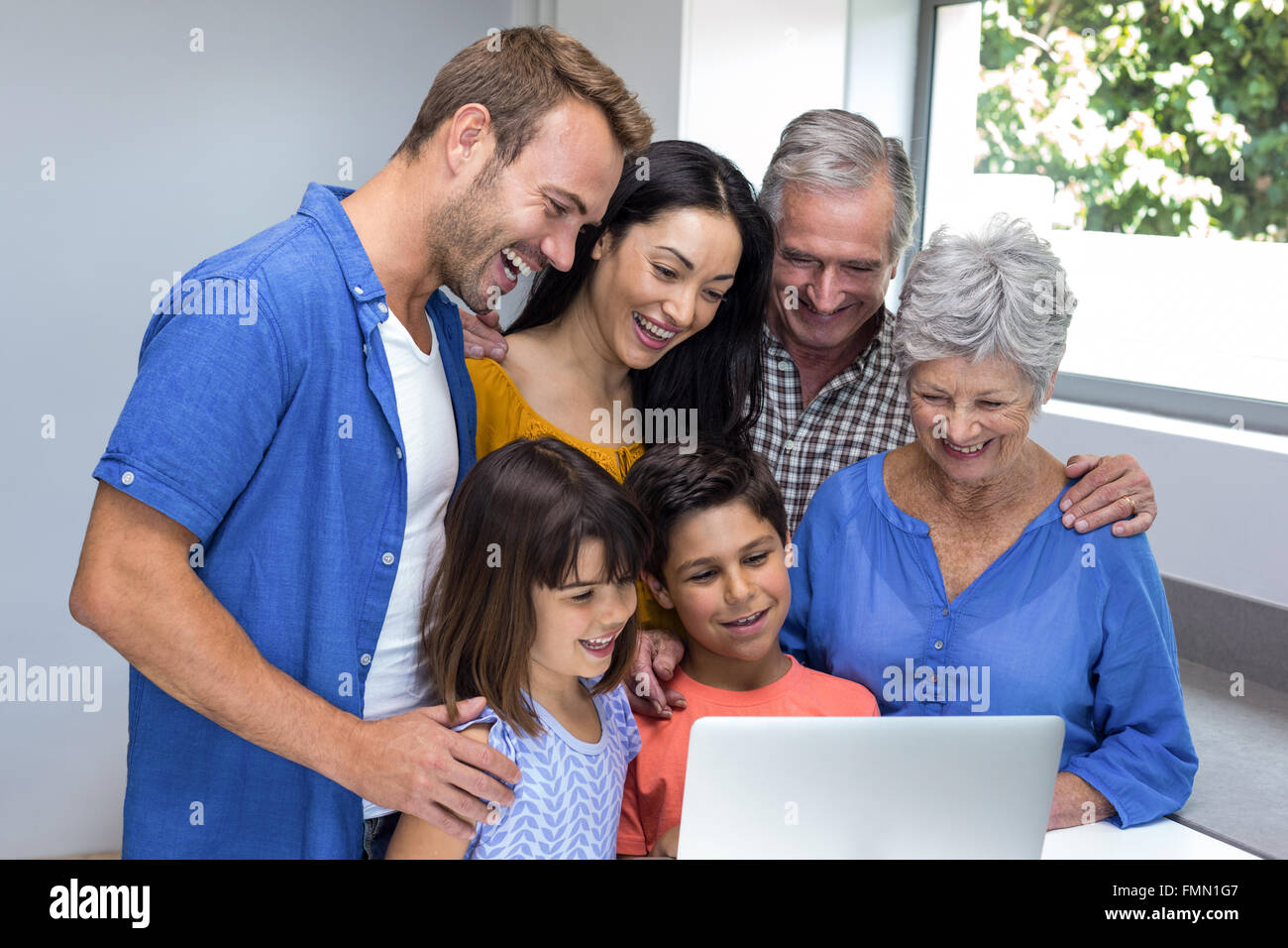 Happy family interacting using laptop Stock Photo - Alamy