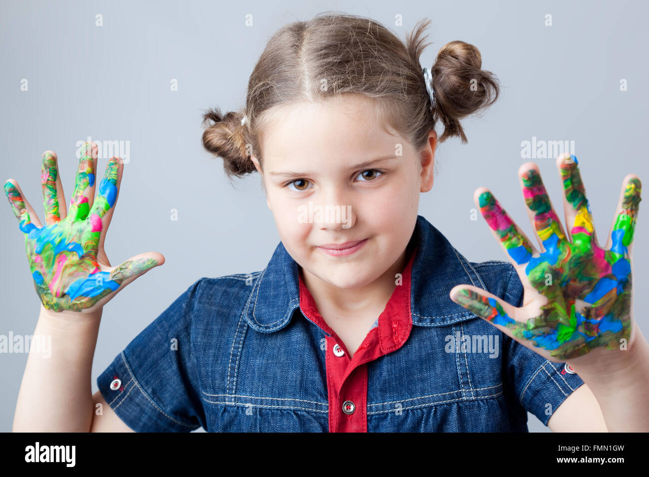 Beautiful little girl showing painted hands over grey background Stock ...