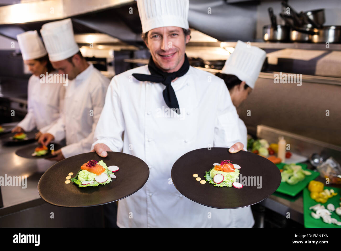 Happy head chef presenting his food plates Stock Photo - Alamy