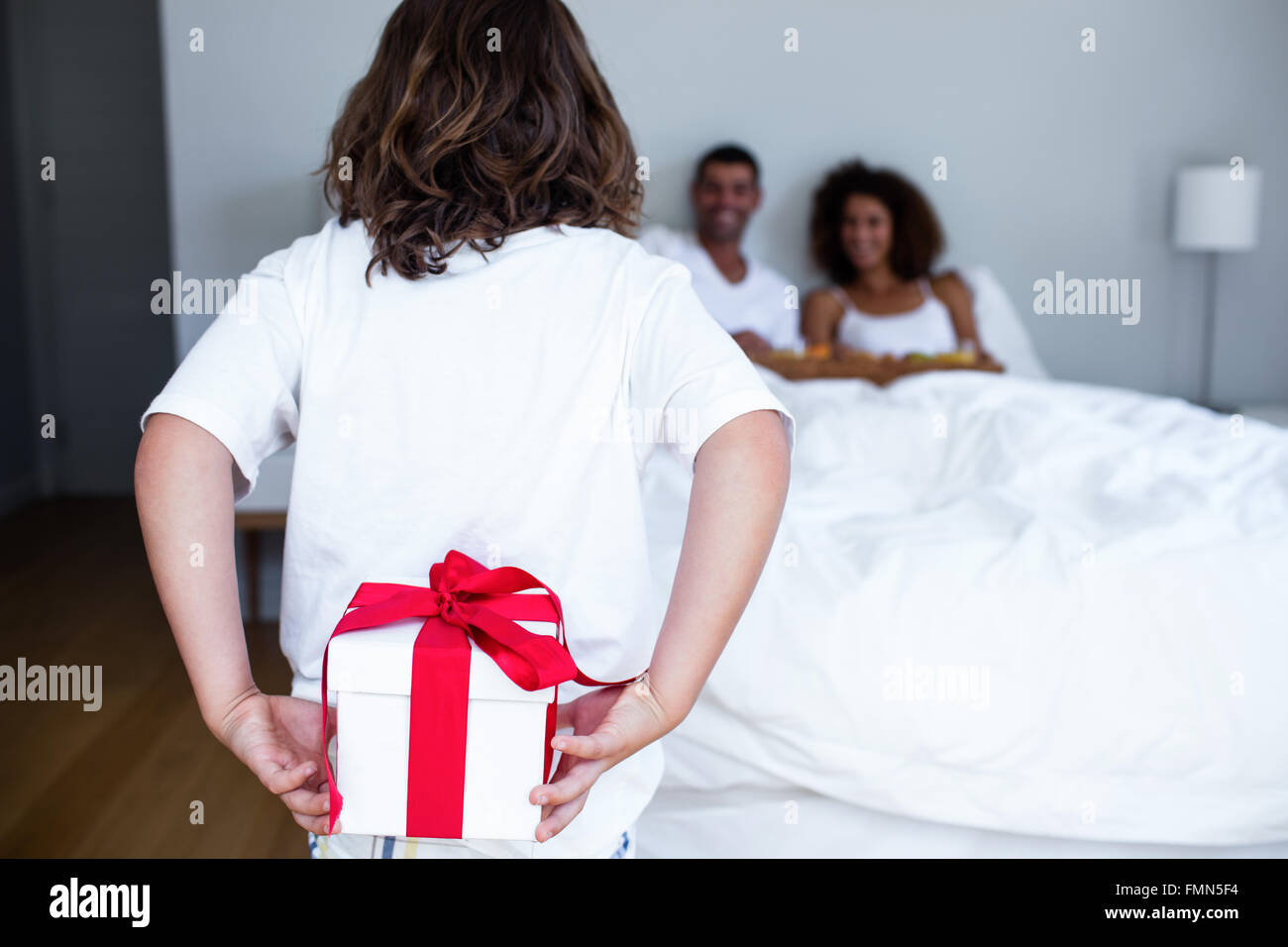 Boy hiding gift behind his back hi-res stock photography and images - Alamy