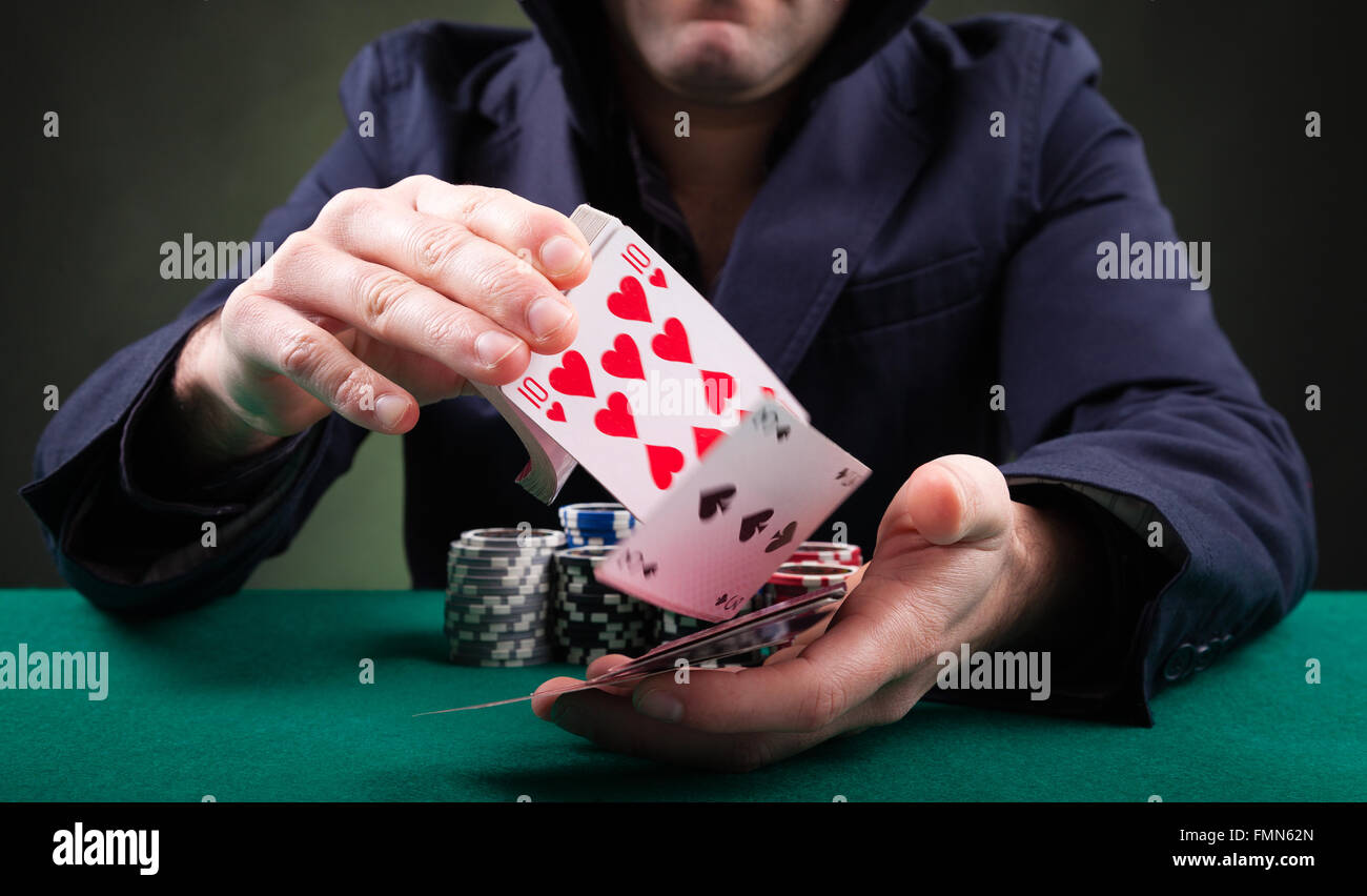Poker player throwing cards on black background Stock Photo - Alamy