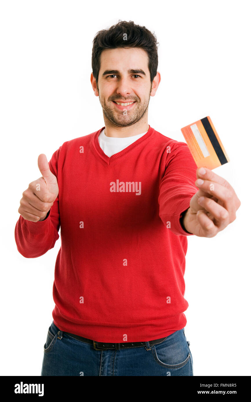 Happy smiling young man holding a credit card and gives thumb up ...