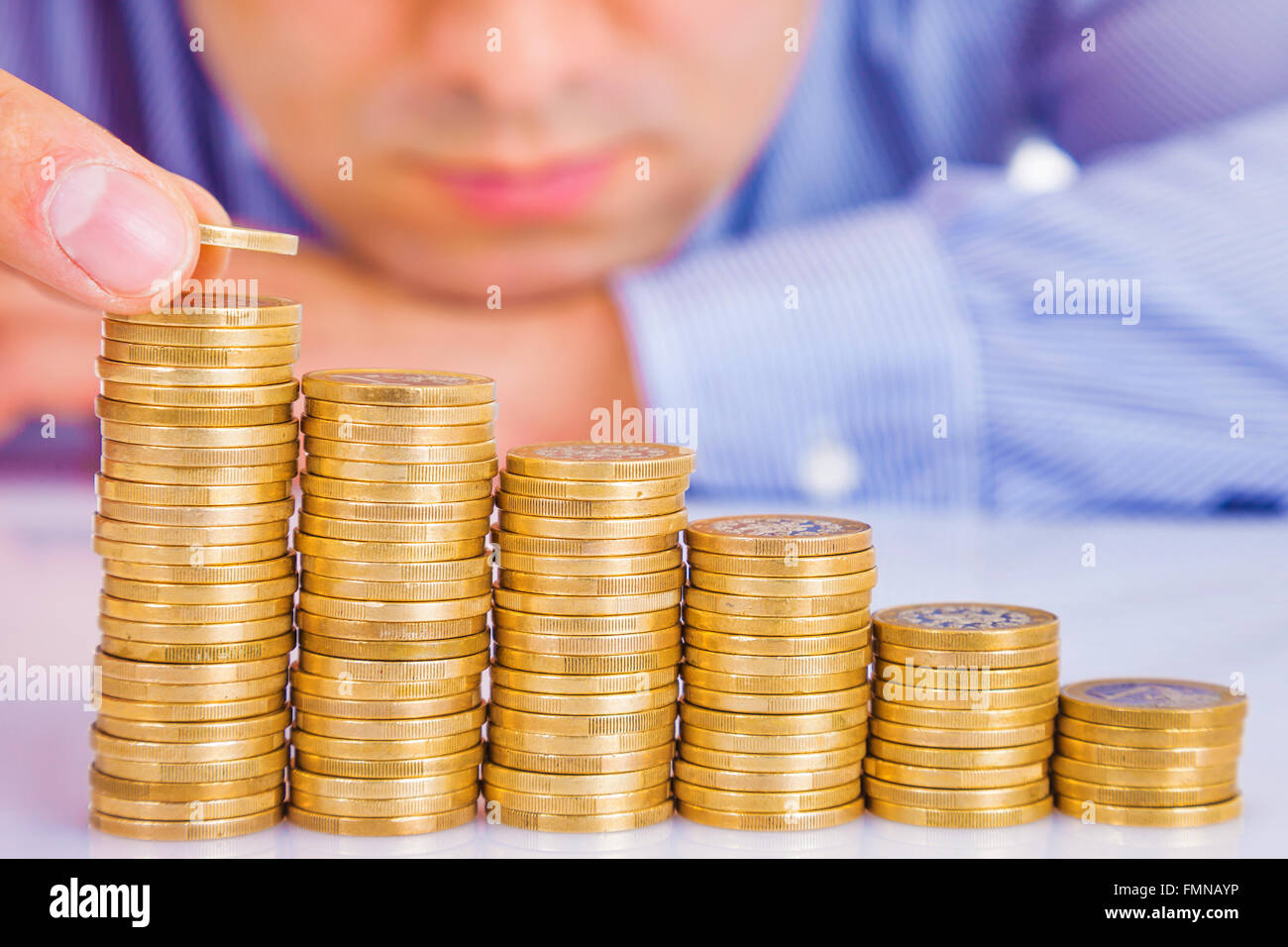 A Businessman rising coins Stock Photo - Alamy