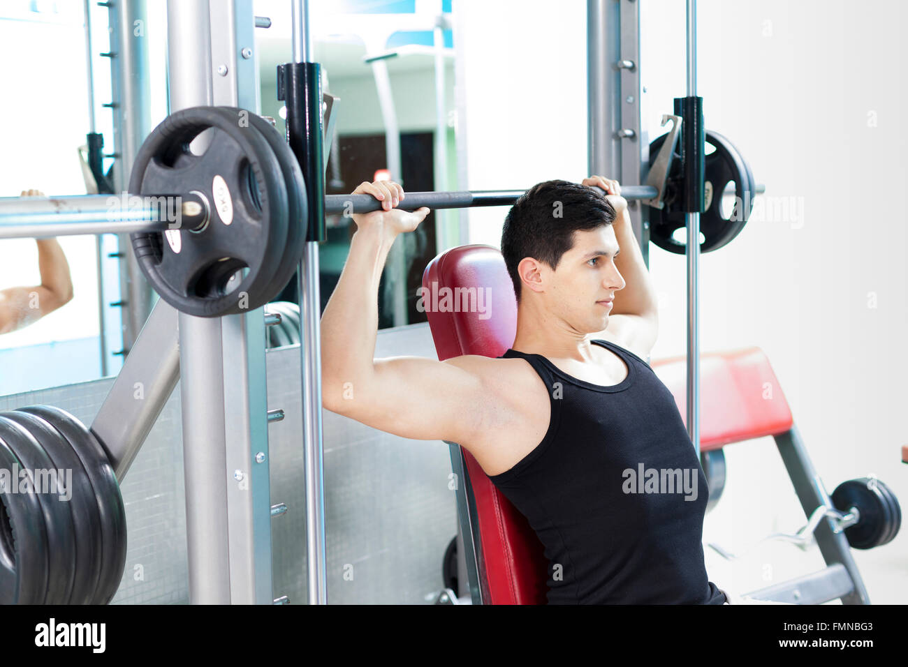 Handsome man lifting heavy weights at the gym Stock Photo - Alamy
