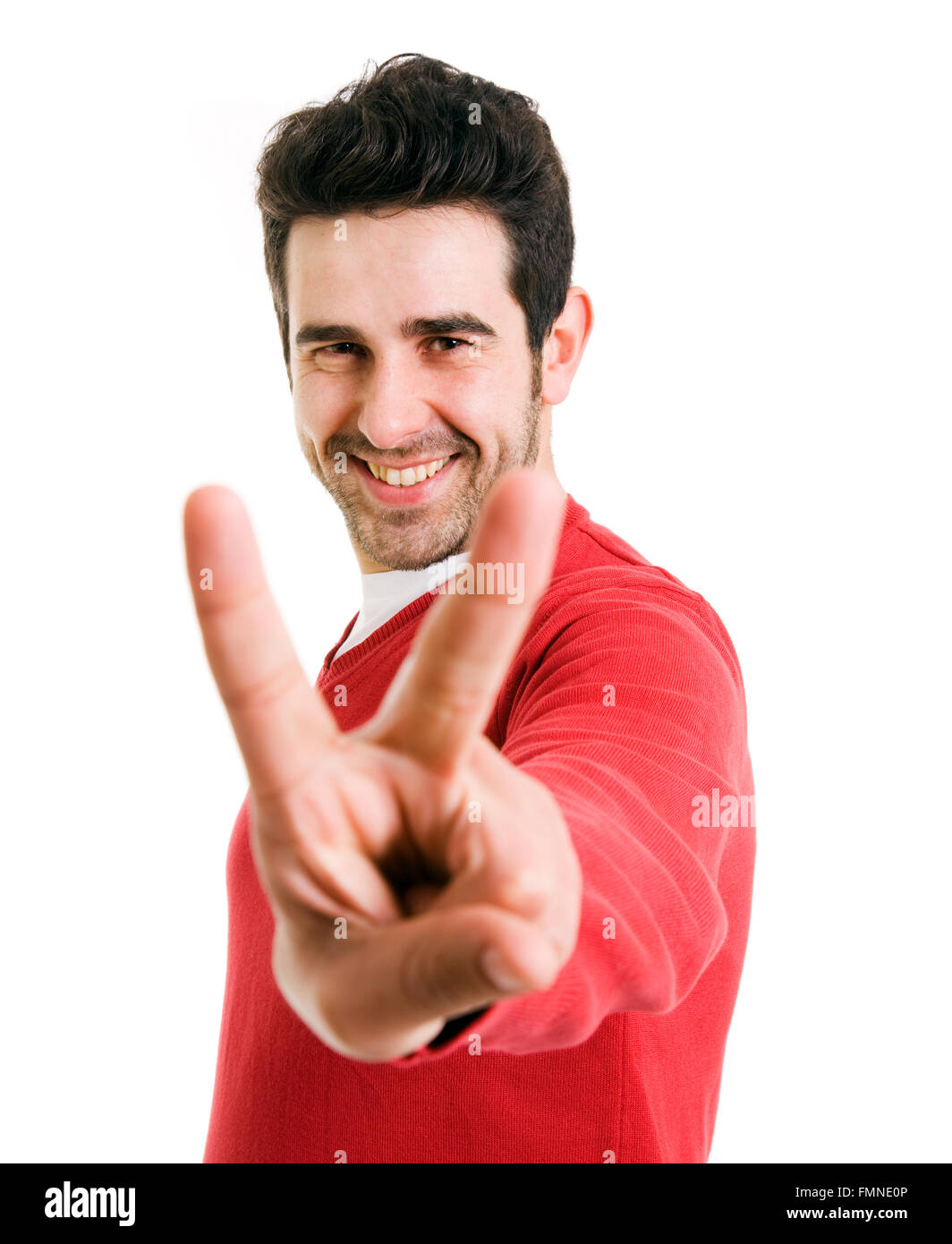 Smiling young man winner gesture against a white background Stock Photo ...