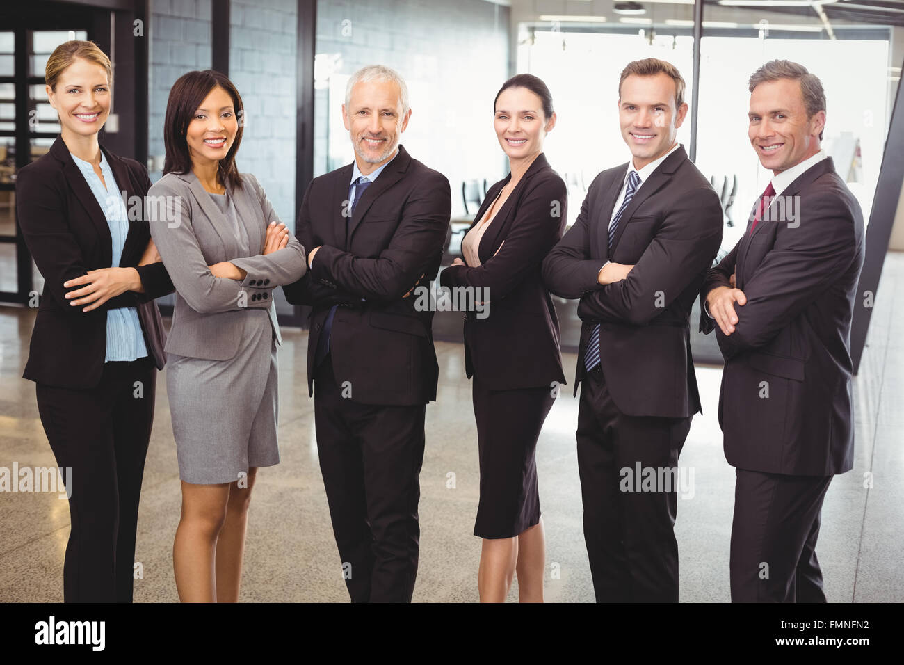 Businesspeople standing with arms crossed Stock Photo - Alamy
